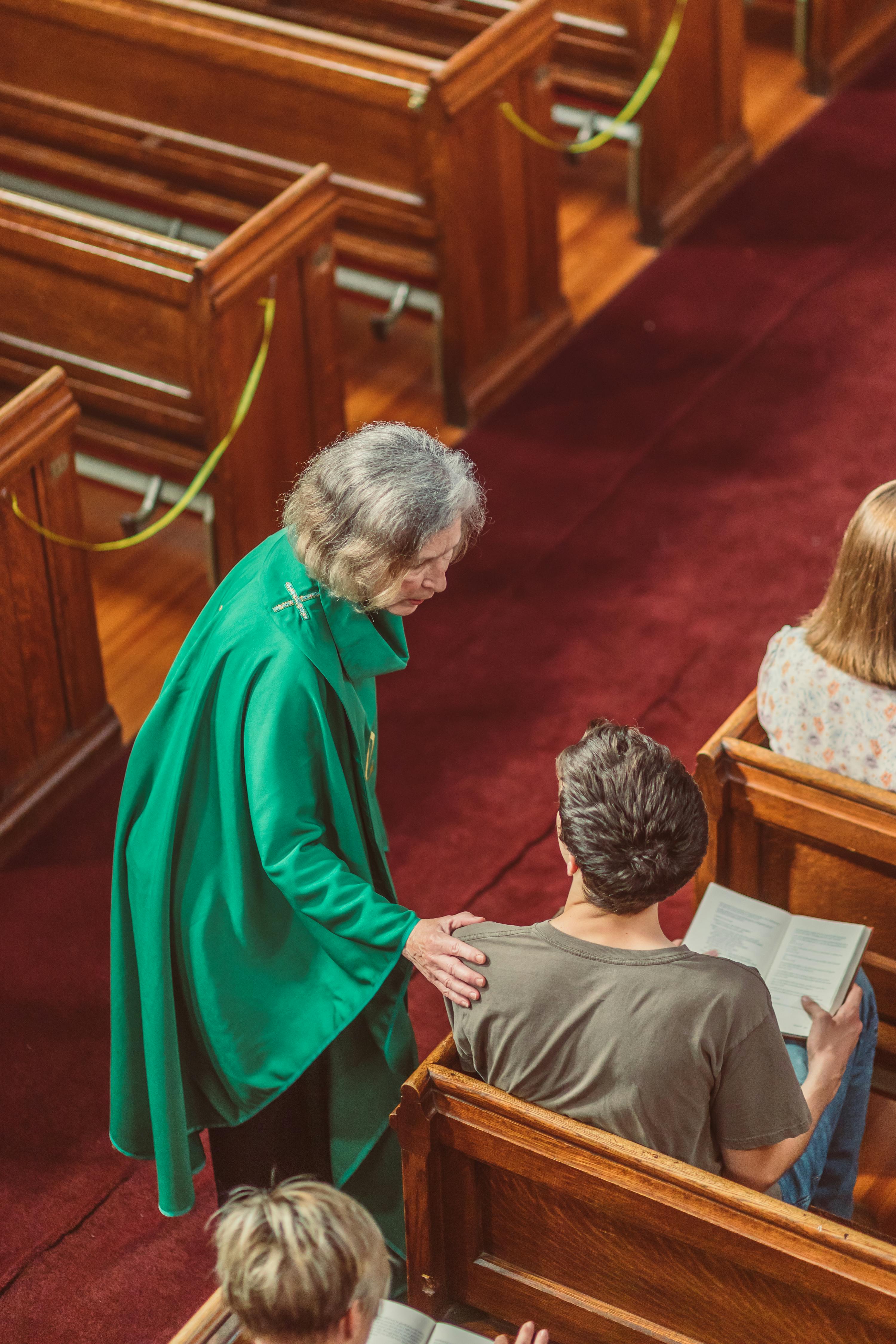 Female Priest Talking to Man Sitting in Church Pew · Free Stock Photo
