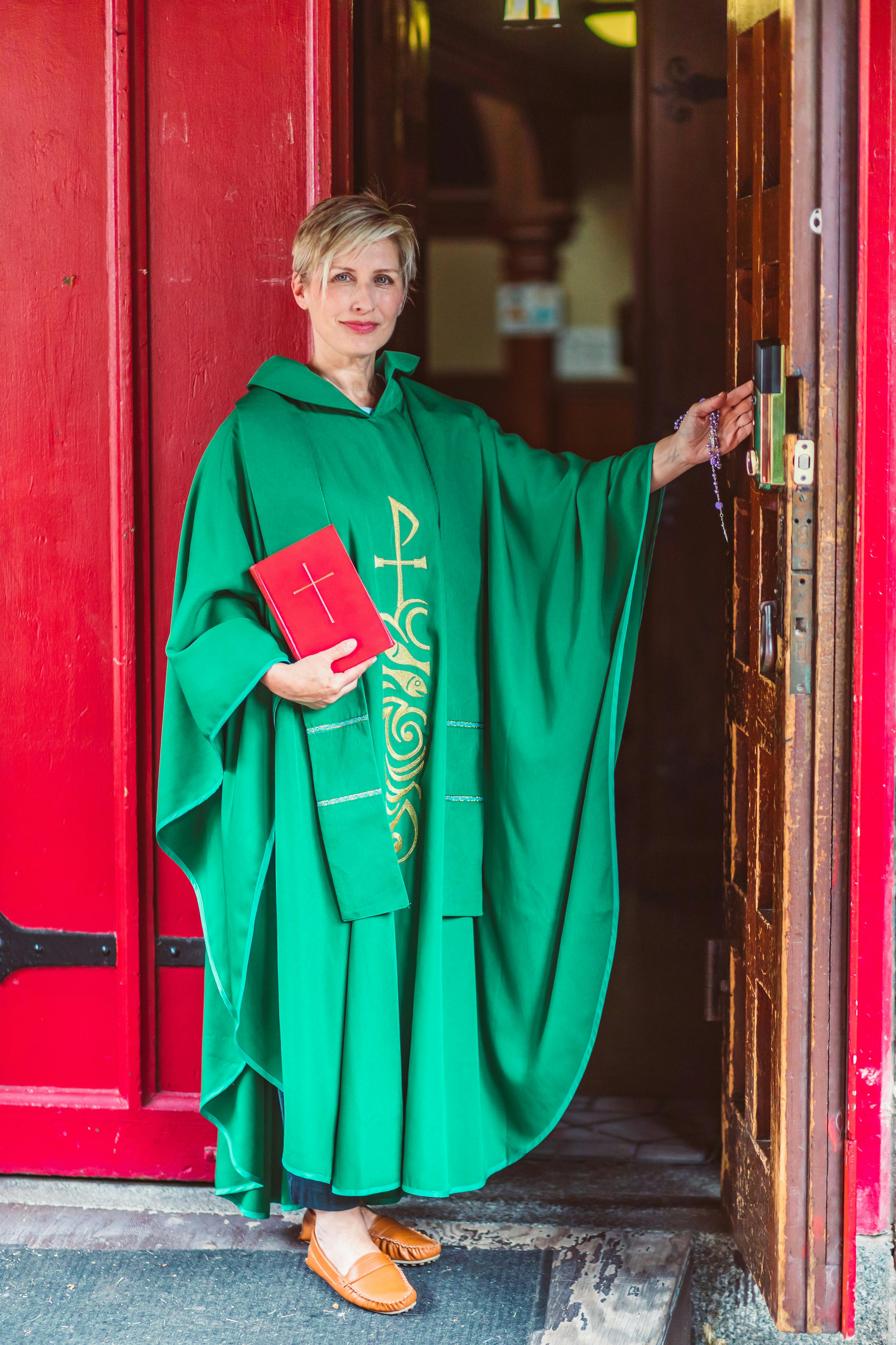 Female Priest in Green Robe holding a Bible · Free Stock Photo
