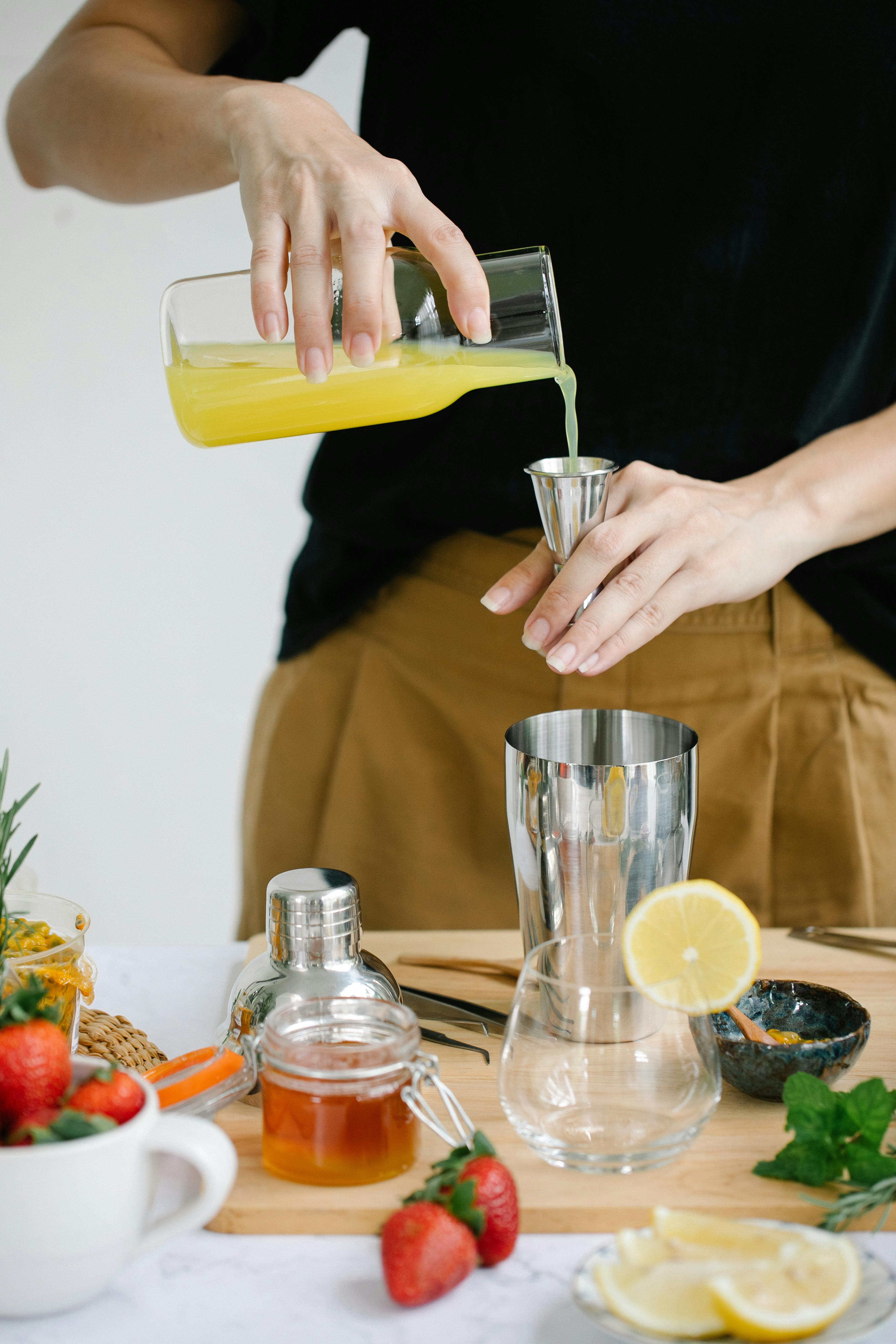 Person Pouring Yellow Liquid in Stainless Steel Cocktail Jigger · Free ...