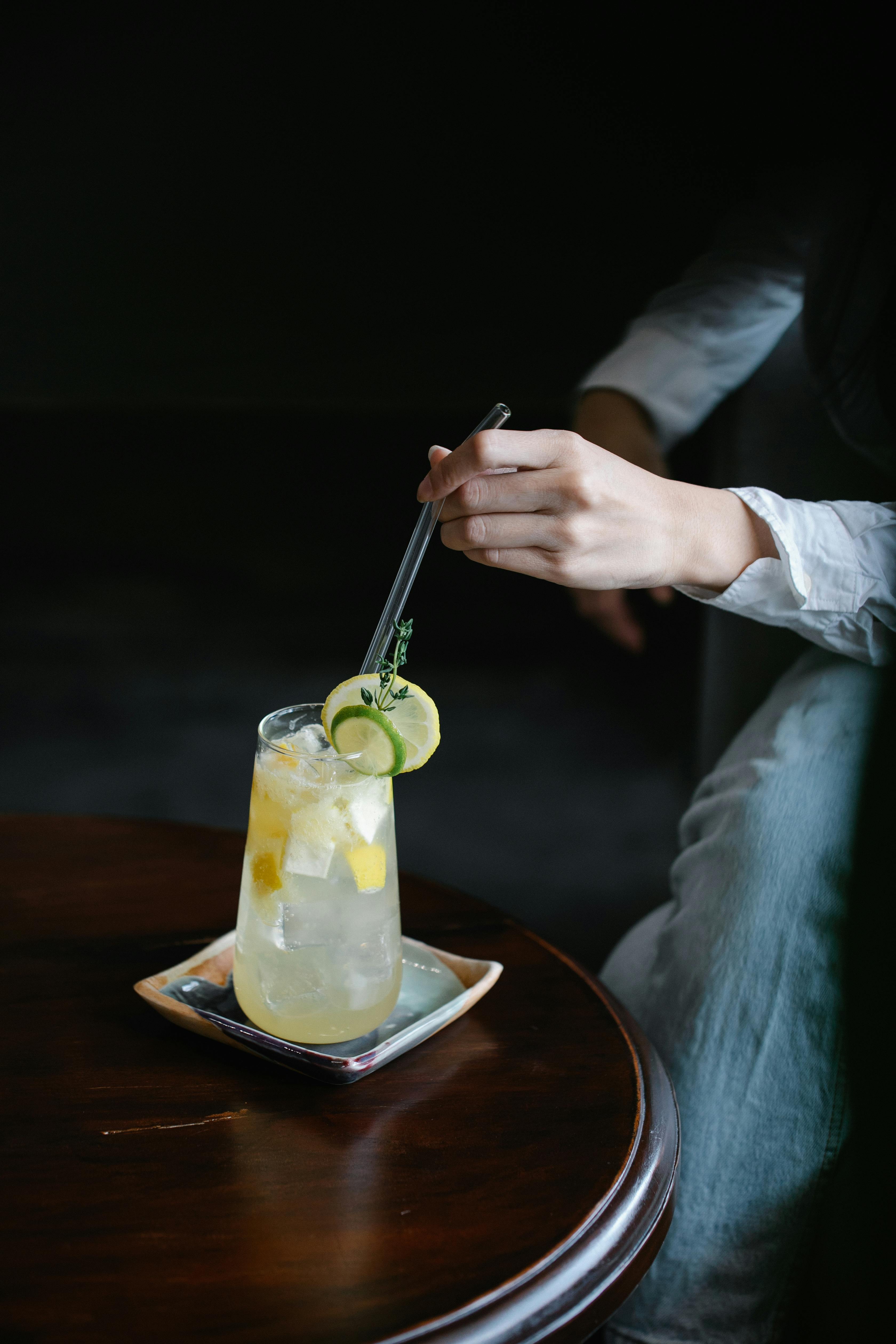 Woman Stirring Lemonade with a Straw · Free Stock Photo