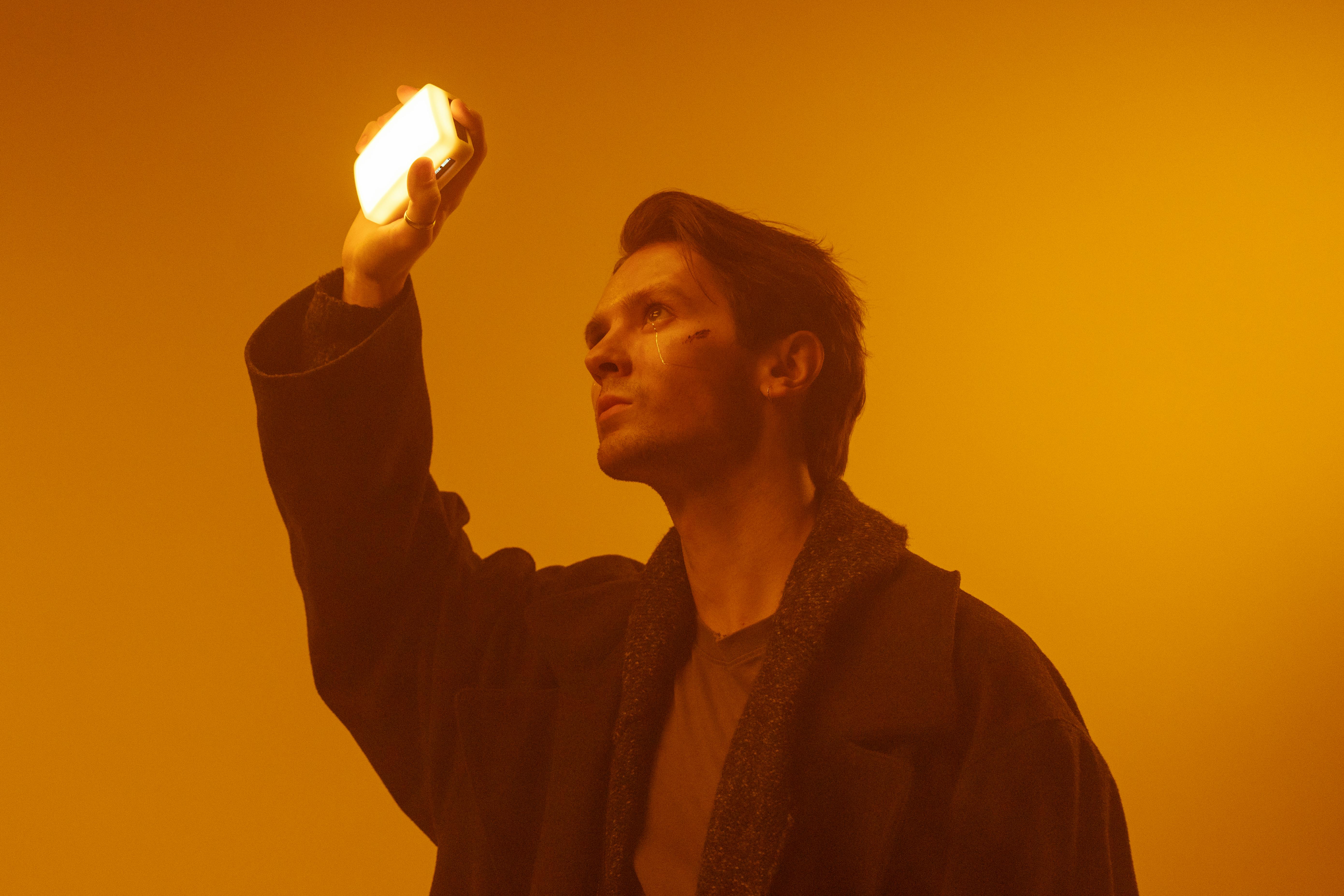 Man Holding a Light in Orange Light · Free Stock Photo