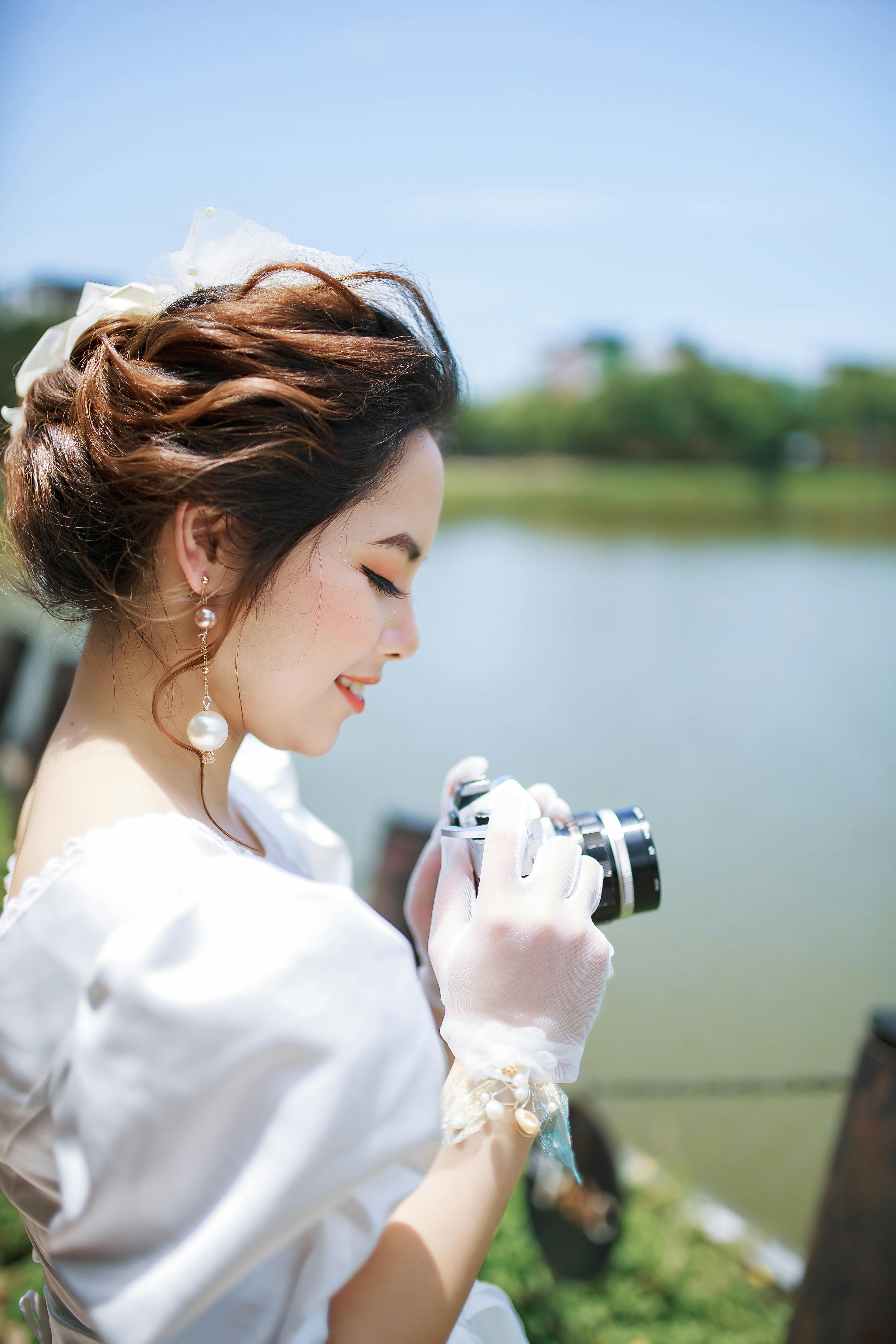 A Beautiful Bride Looking at the DSLR Camera she is Holding · Free ...