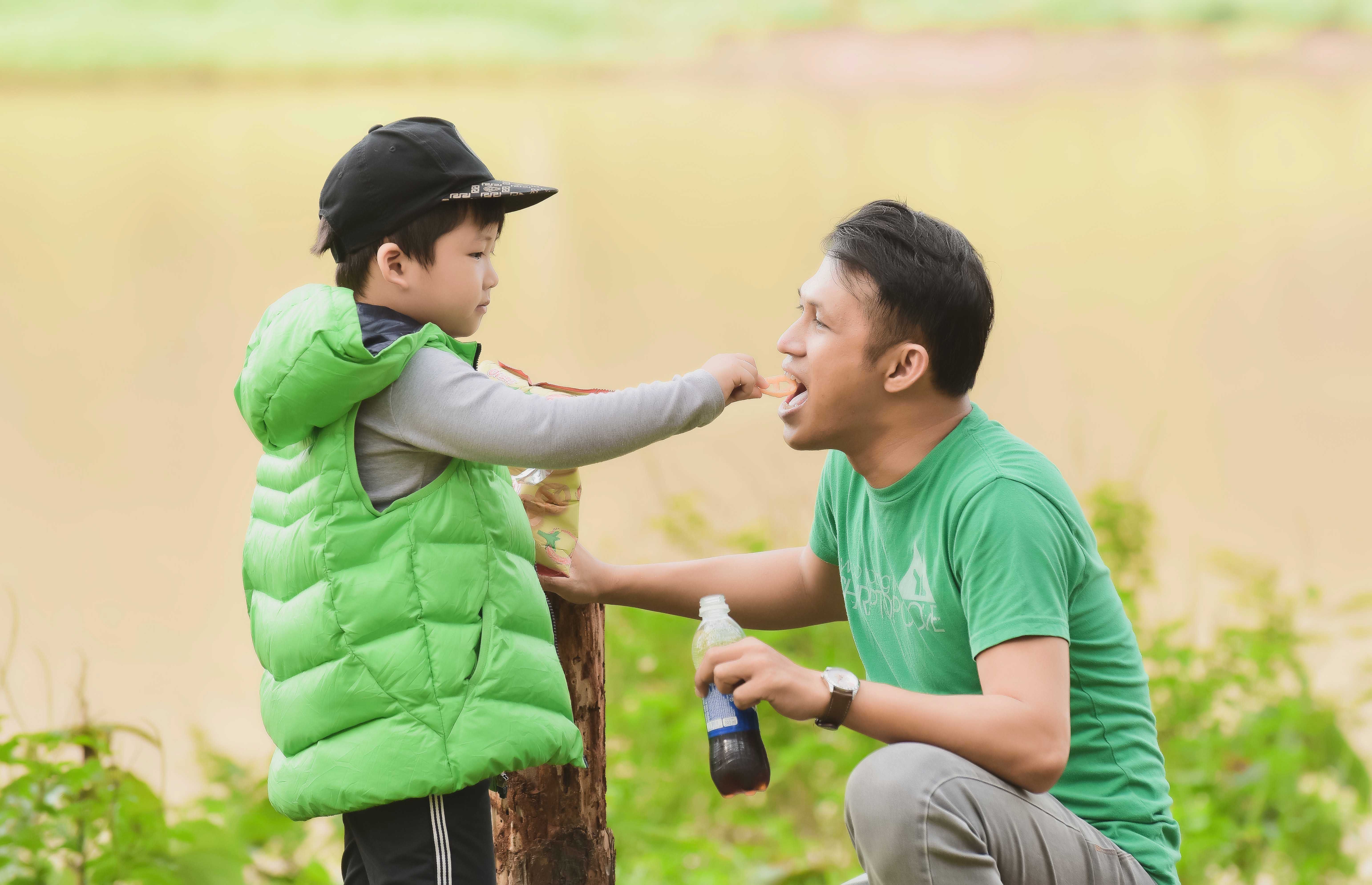 Boy Feeding a Man · Free Stock Photo
