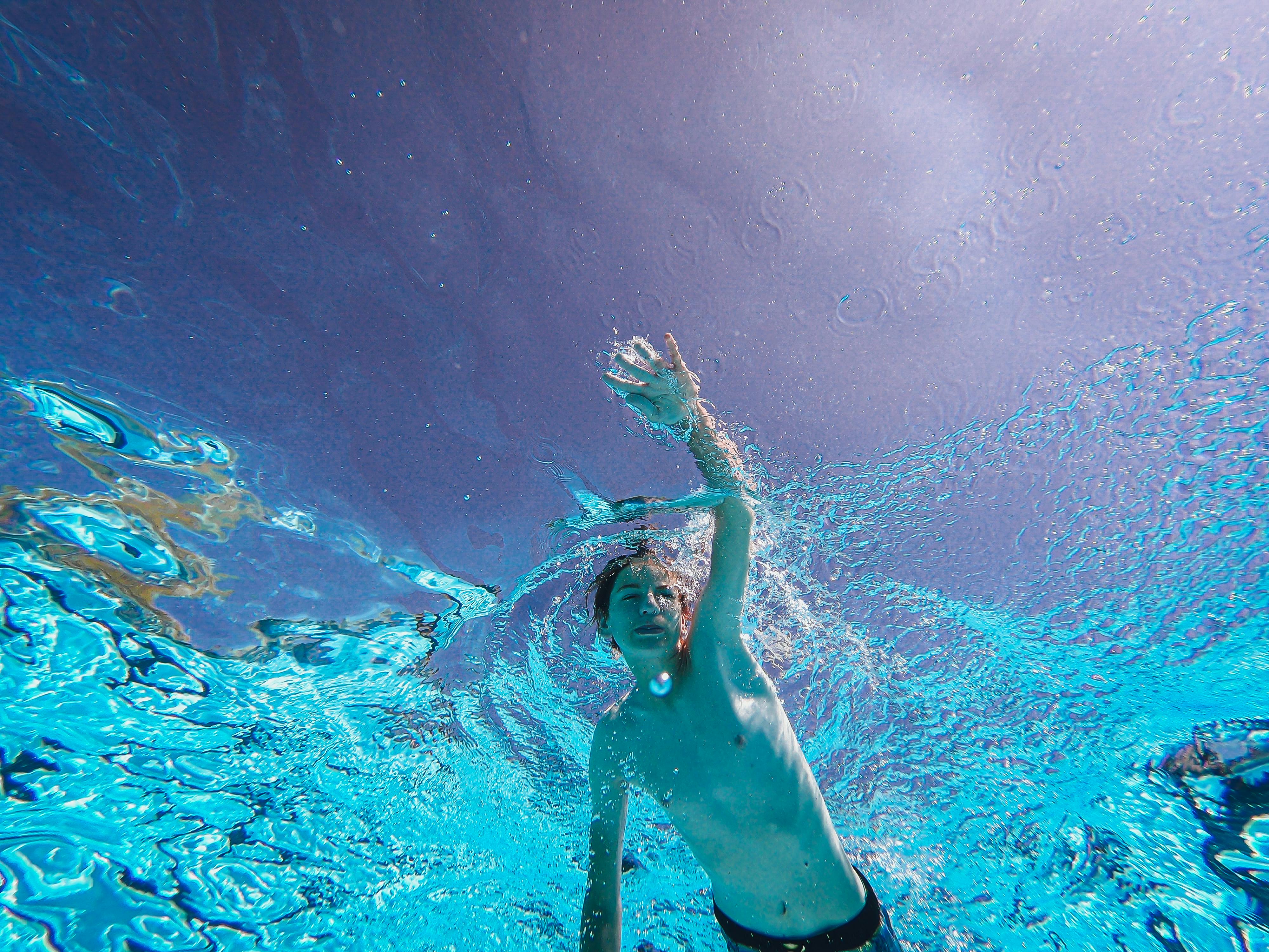 Shirtless Man Swimming in a Pool · Free Stock Photo