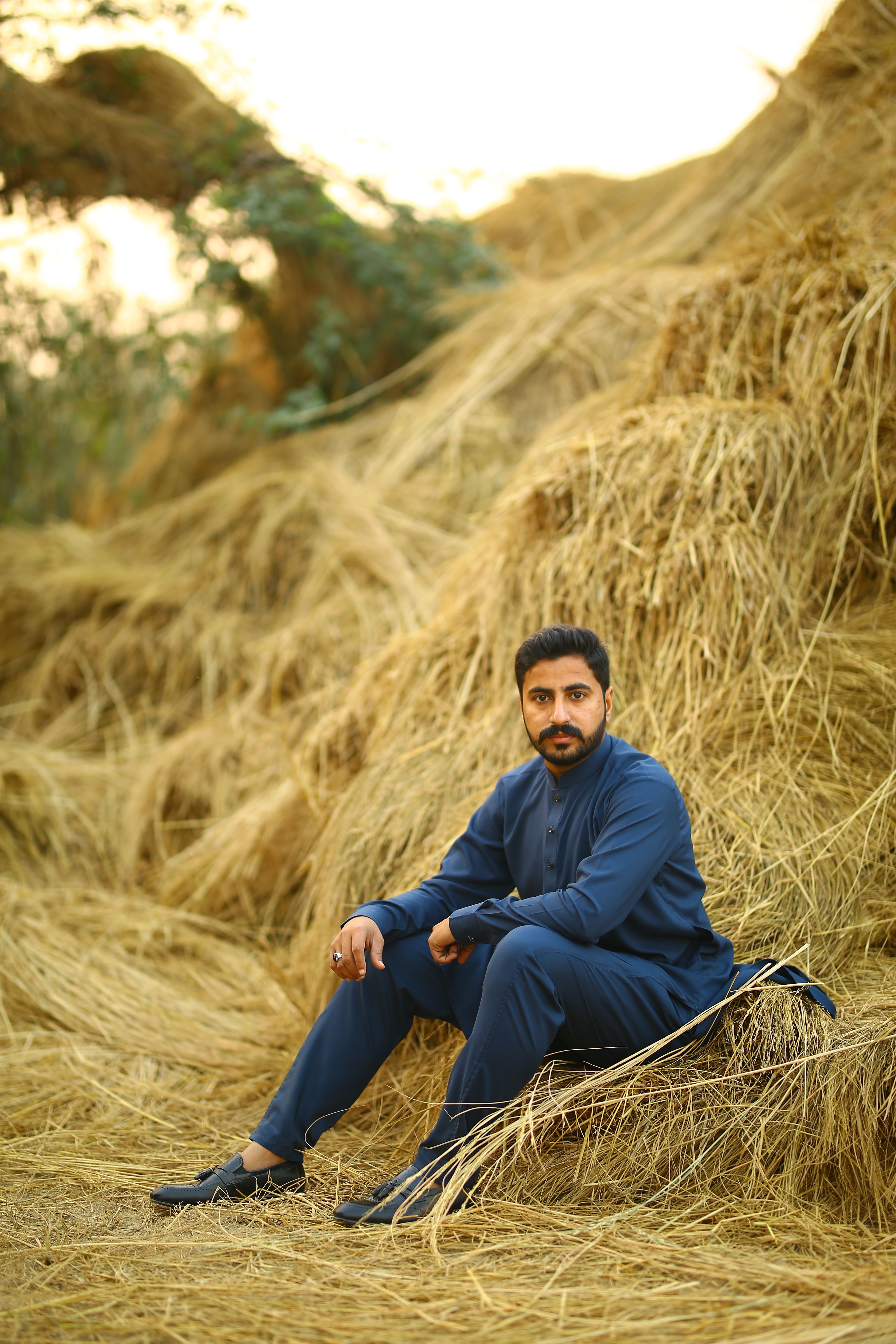 Man in Blue Long Sleeves Sitting on Hay · Free Stock Photo