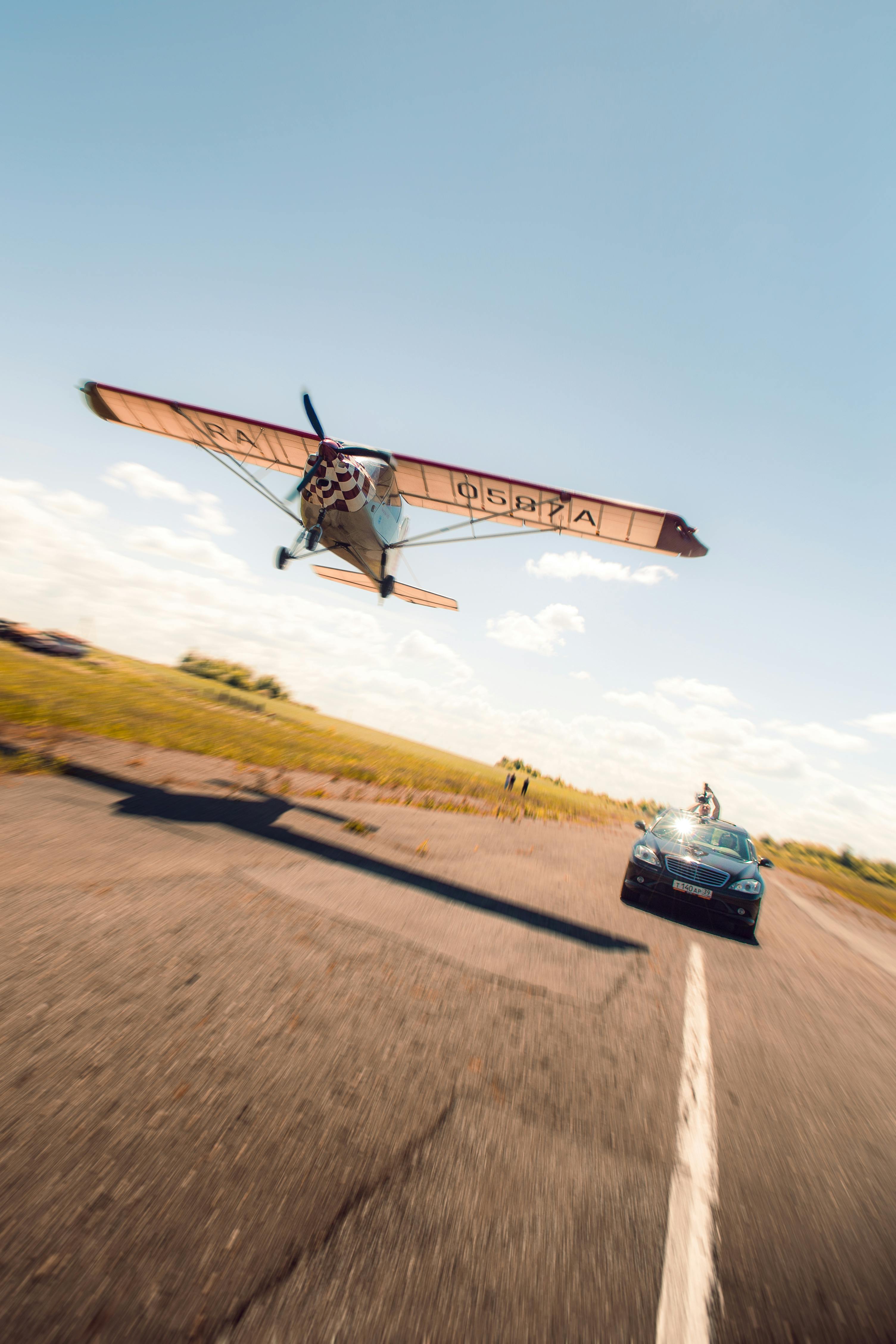 Airplane Flying Over the Black Car · Free Stock Photo