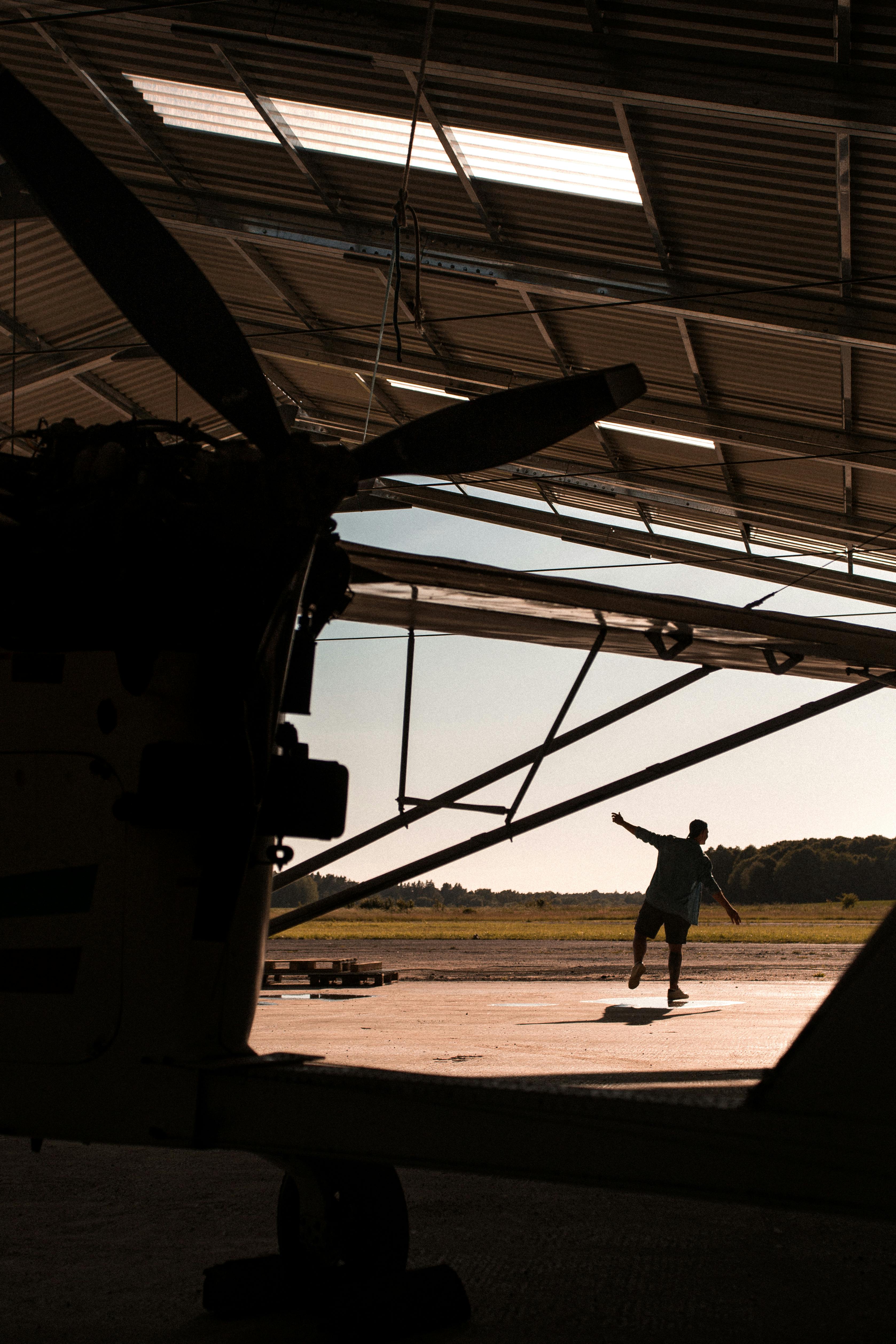 Man Posing in front of Hangar · Free Stock Photo