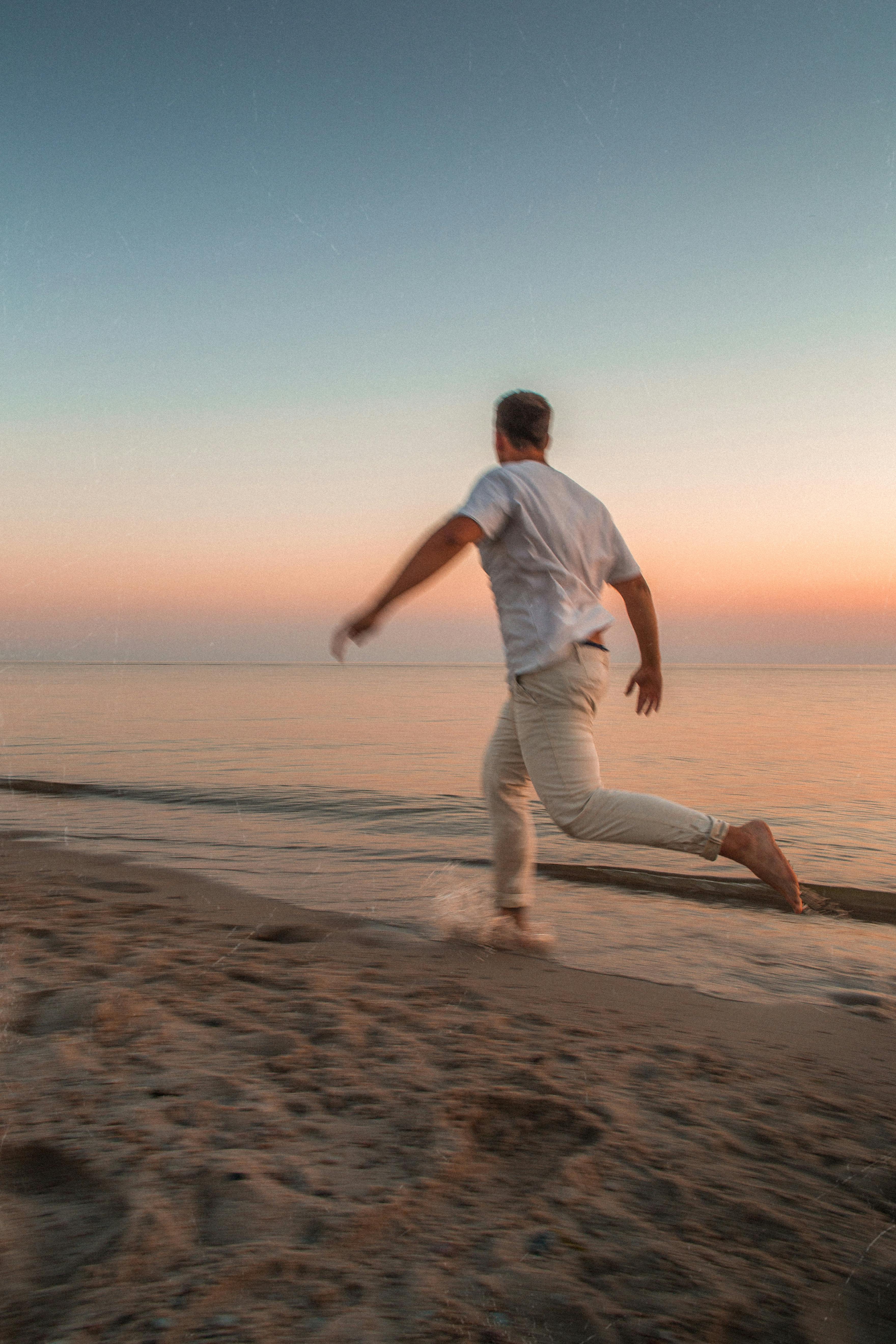 Man Running on Beach at Dusk under Clear Sky · Free Stock Photo