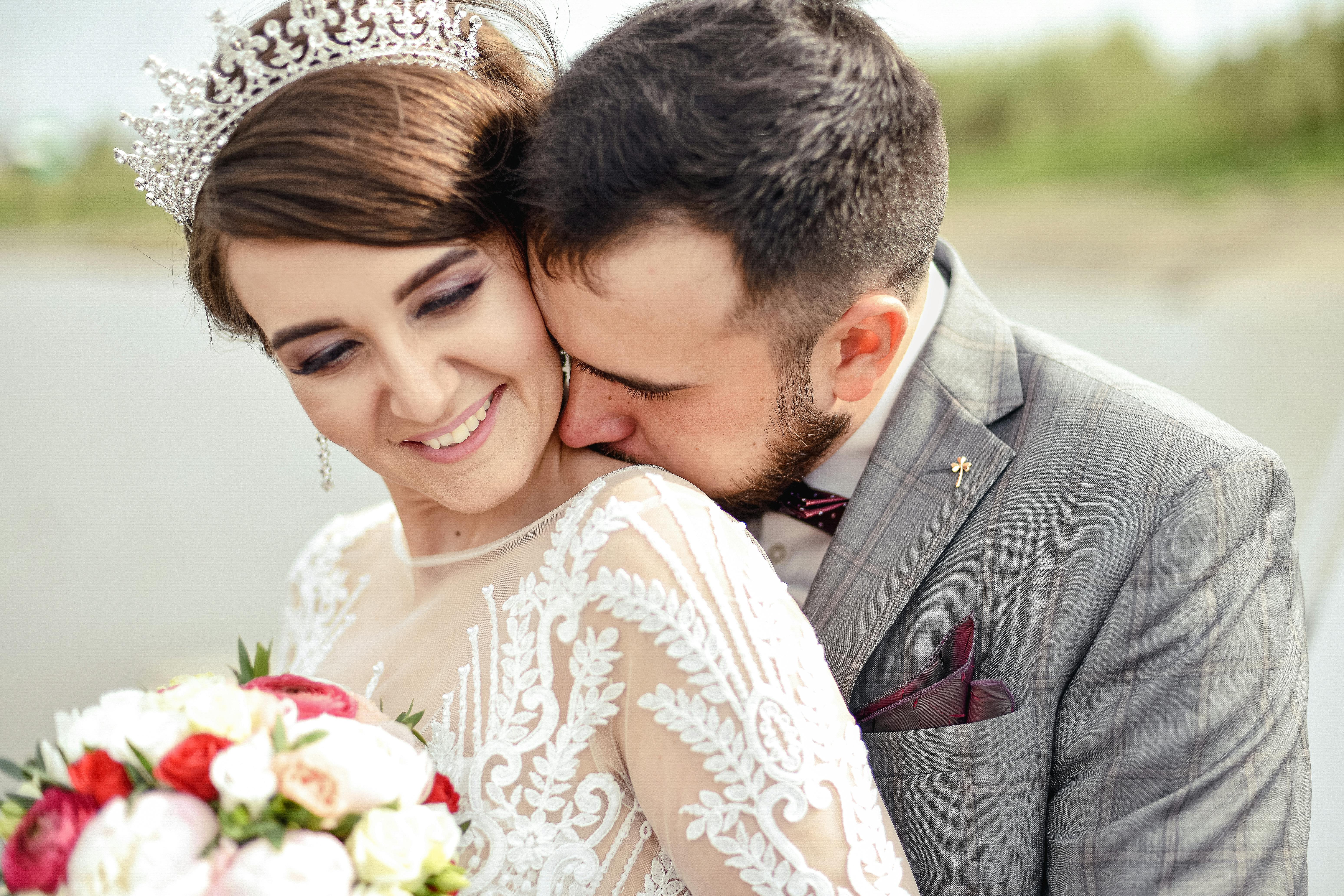 Groom Kissing the Bride on Her Shoulder · Free Stock Photo