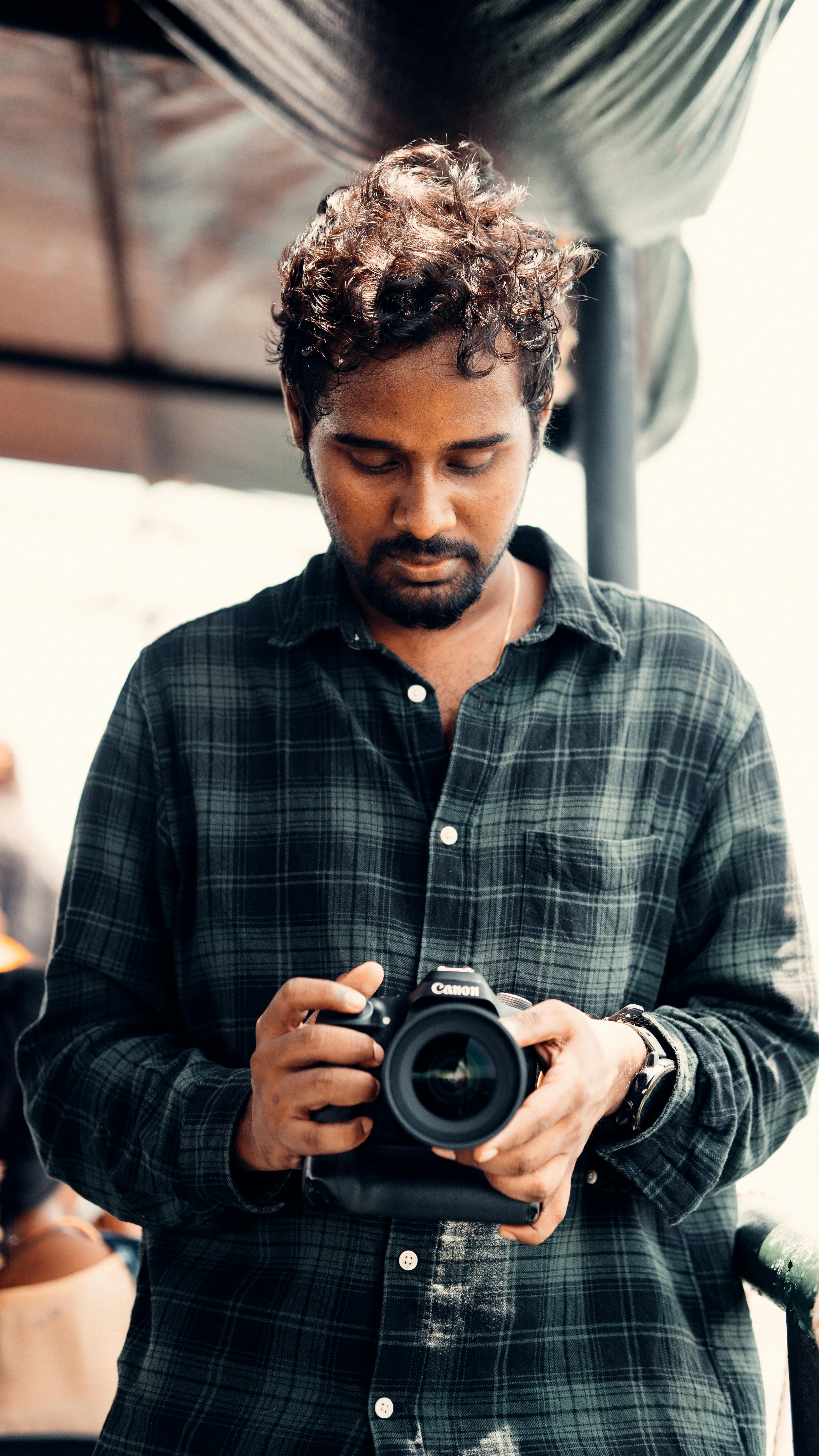 Person in Plaid Shirt with Gray Camera · Free Stock Photo