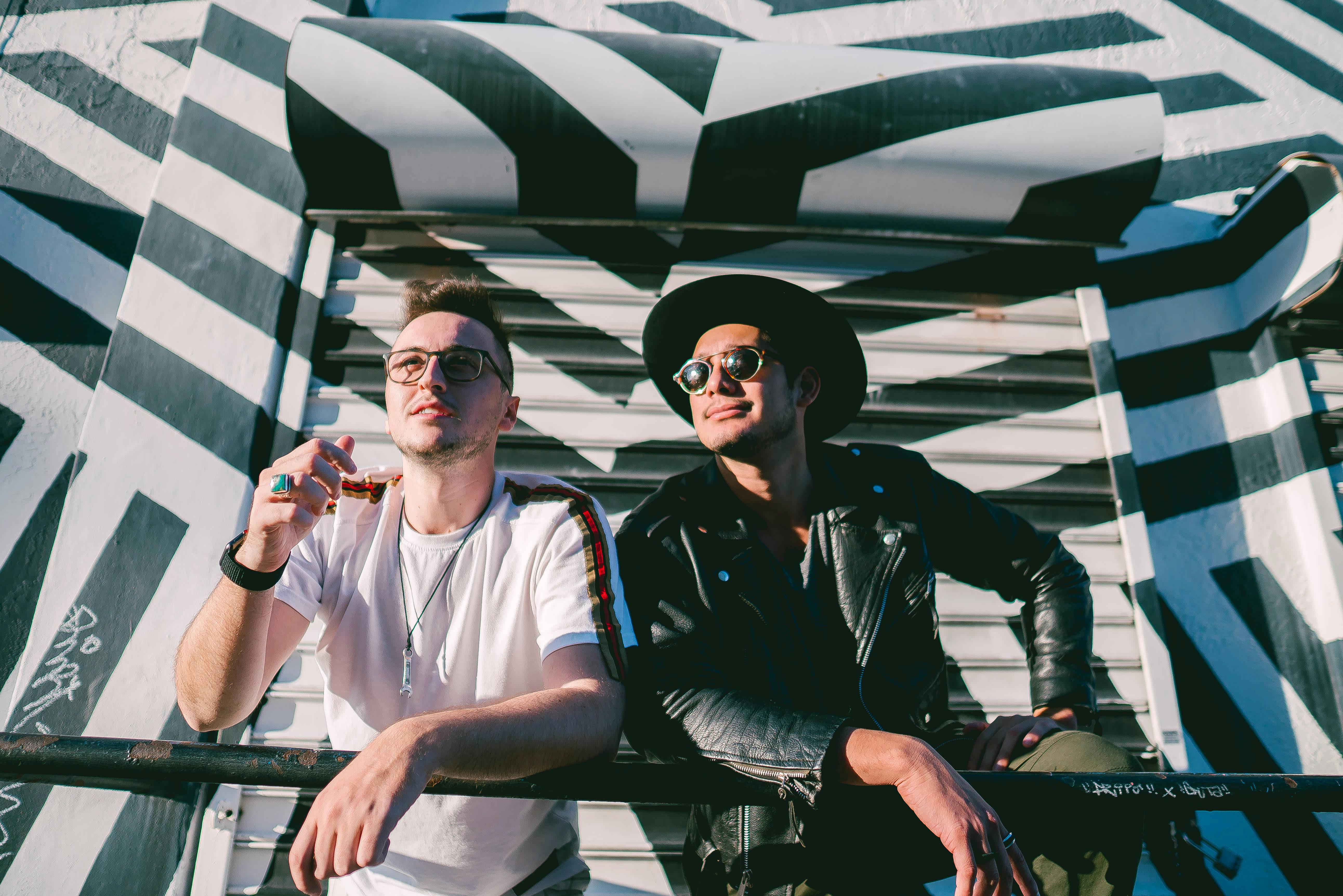 Men Standing Leaning on Metal Railings · Free Stock Photo