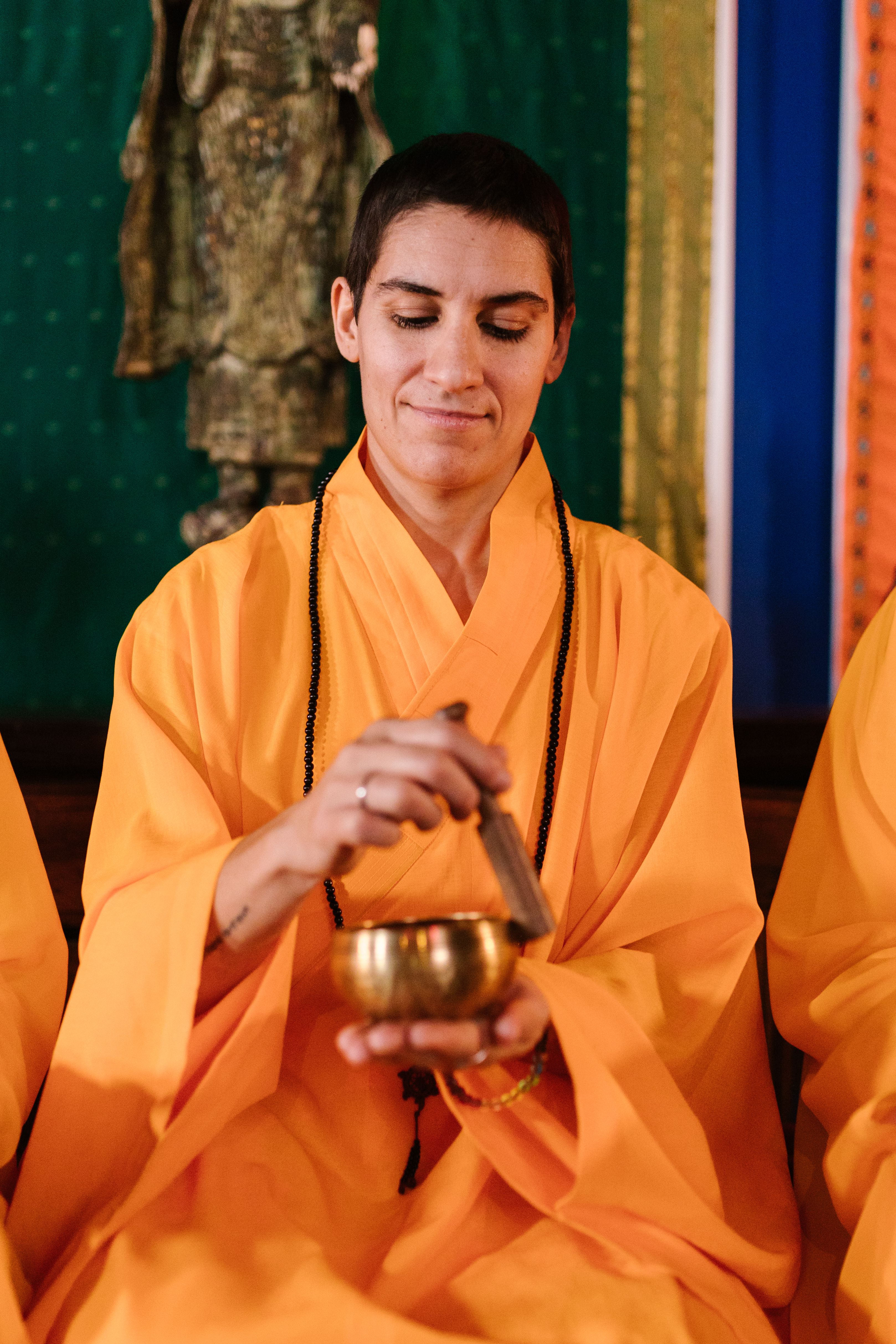 Unrecognizable Asian male monk in traditional orange robe on seashore ...