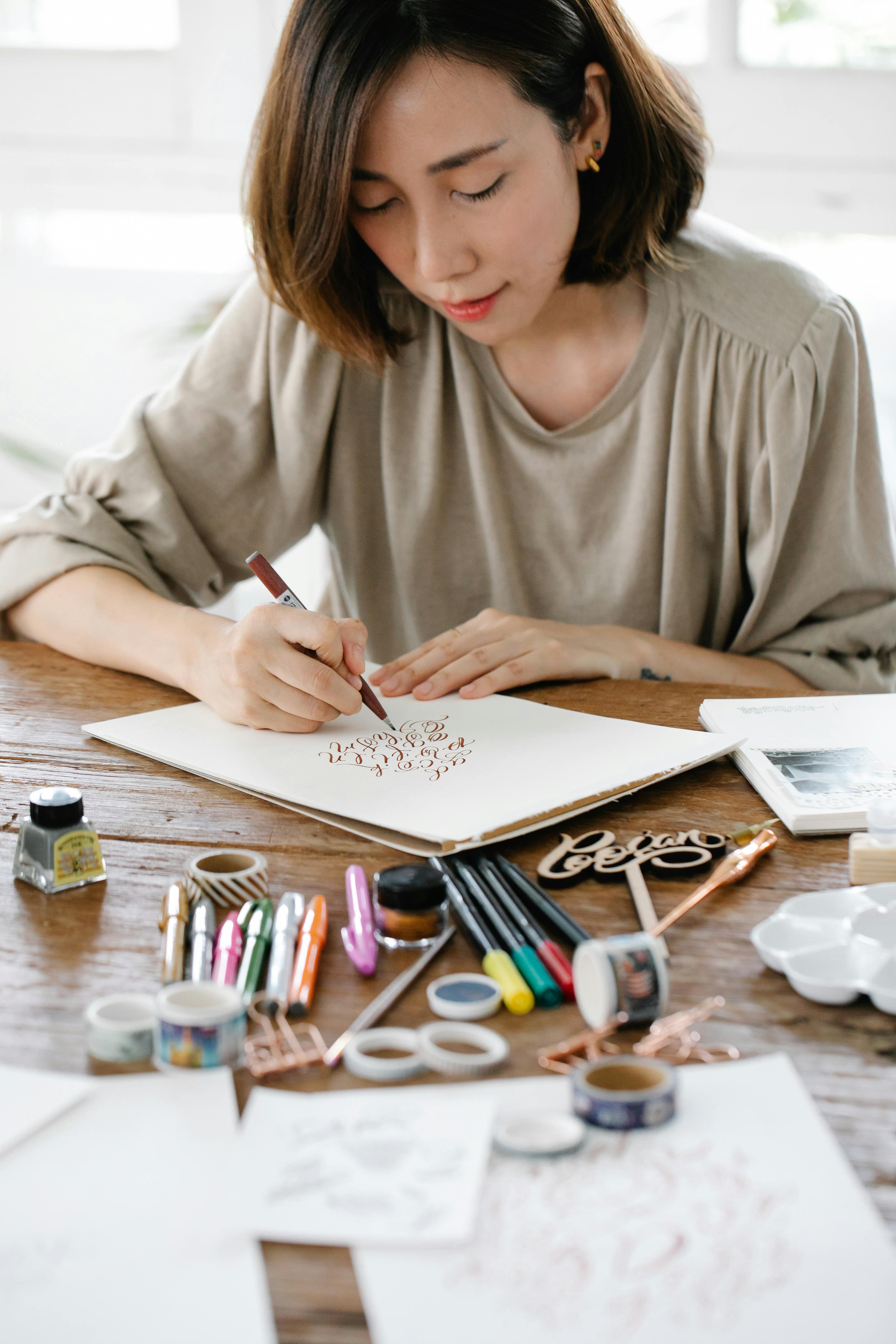 Woman Writing Calligraphy on Paper · Free Stock Photo