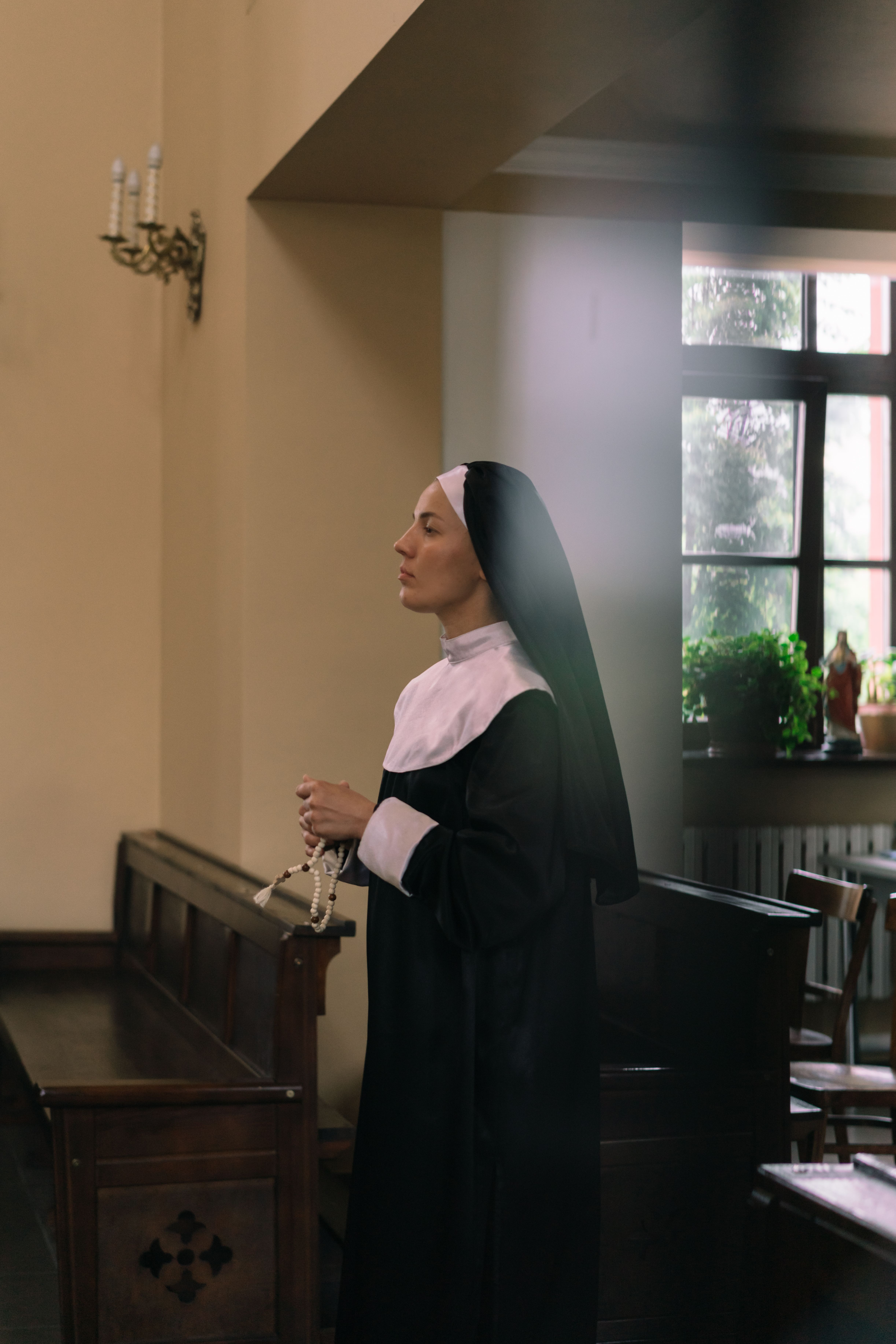 Side View of a Nun Holding a Rosary · Free Stock Photo