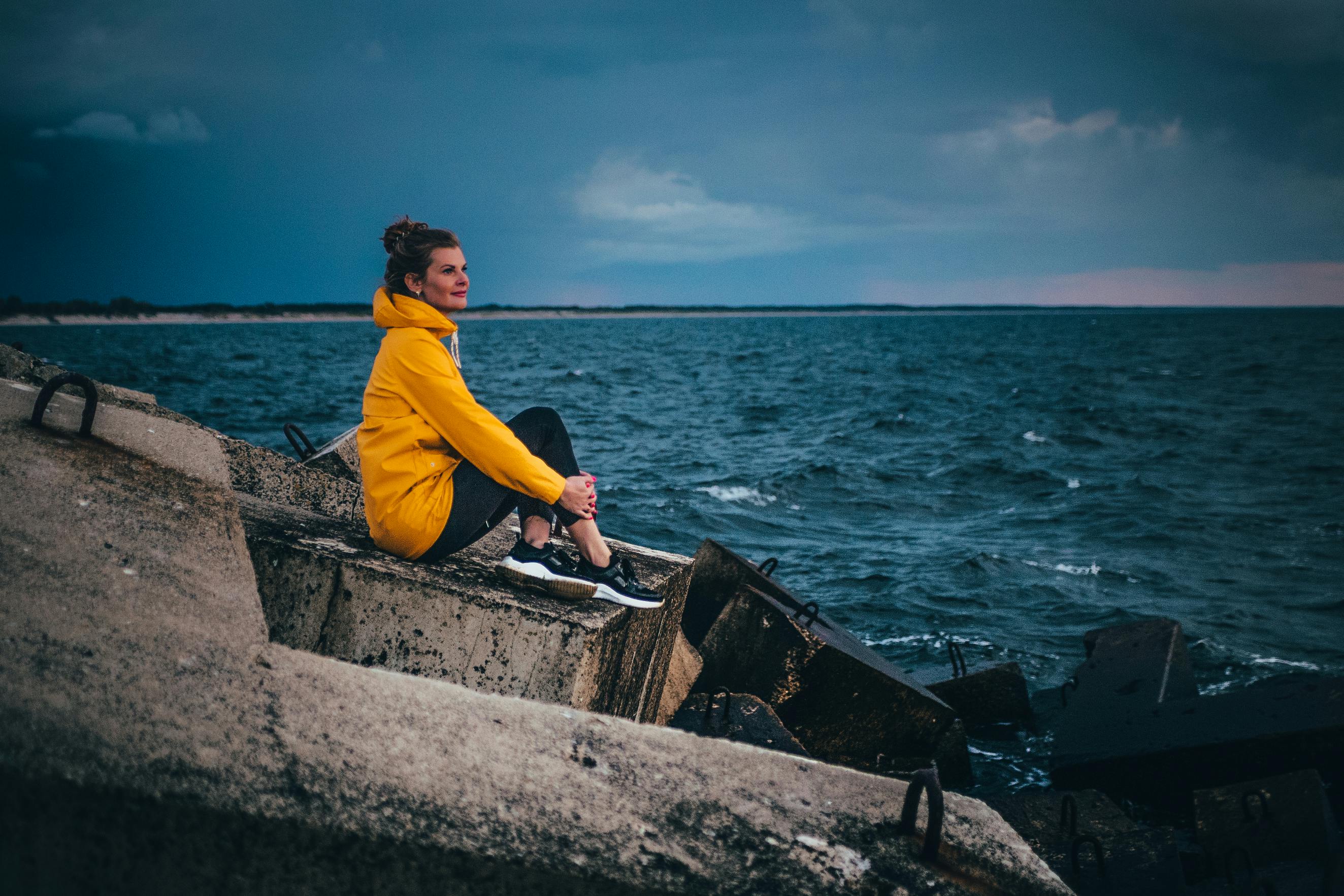 Back View of a Woman Walking on a Breakwater · Free Stock Photo