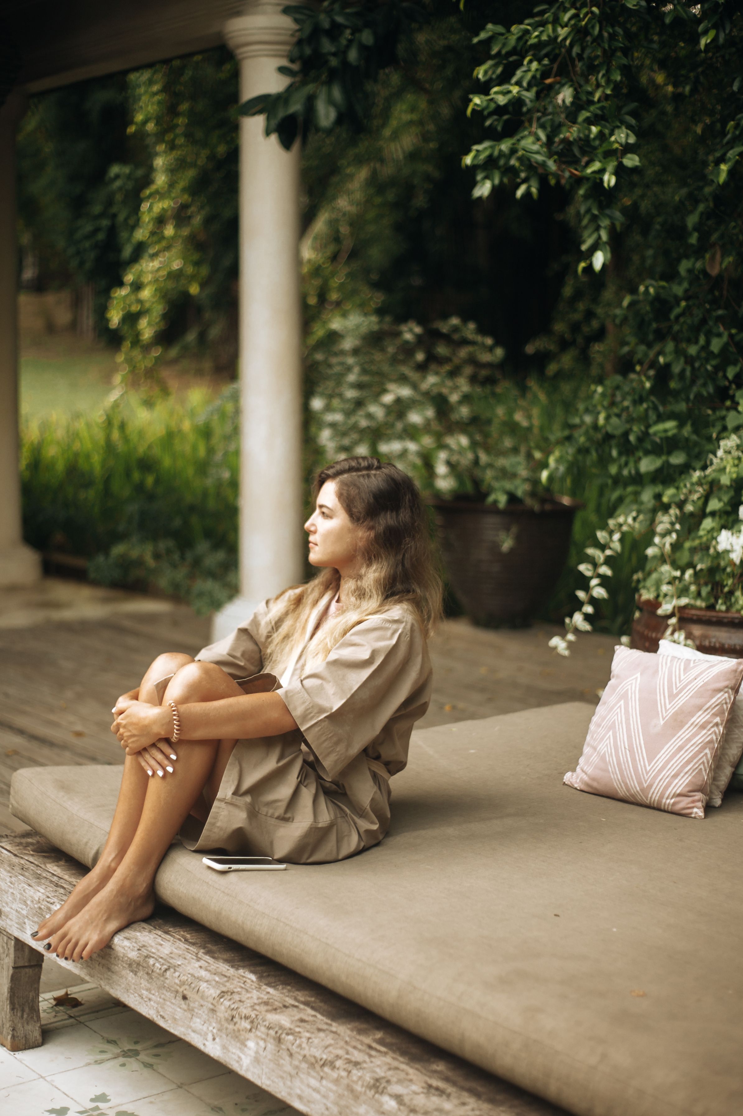 Woman Sitting on an Outdoor Bed on a Patio · Free Stock Photo