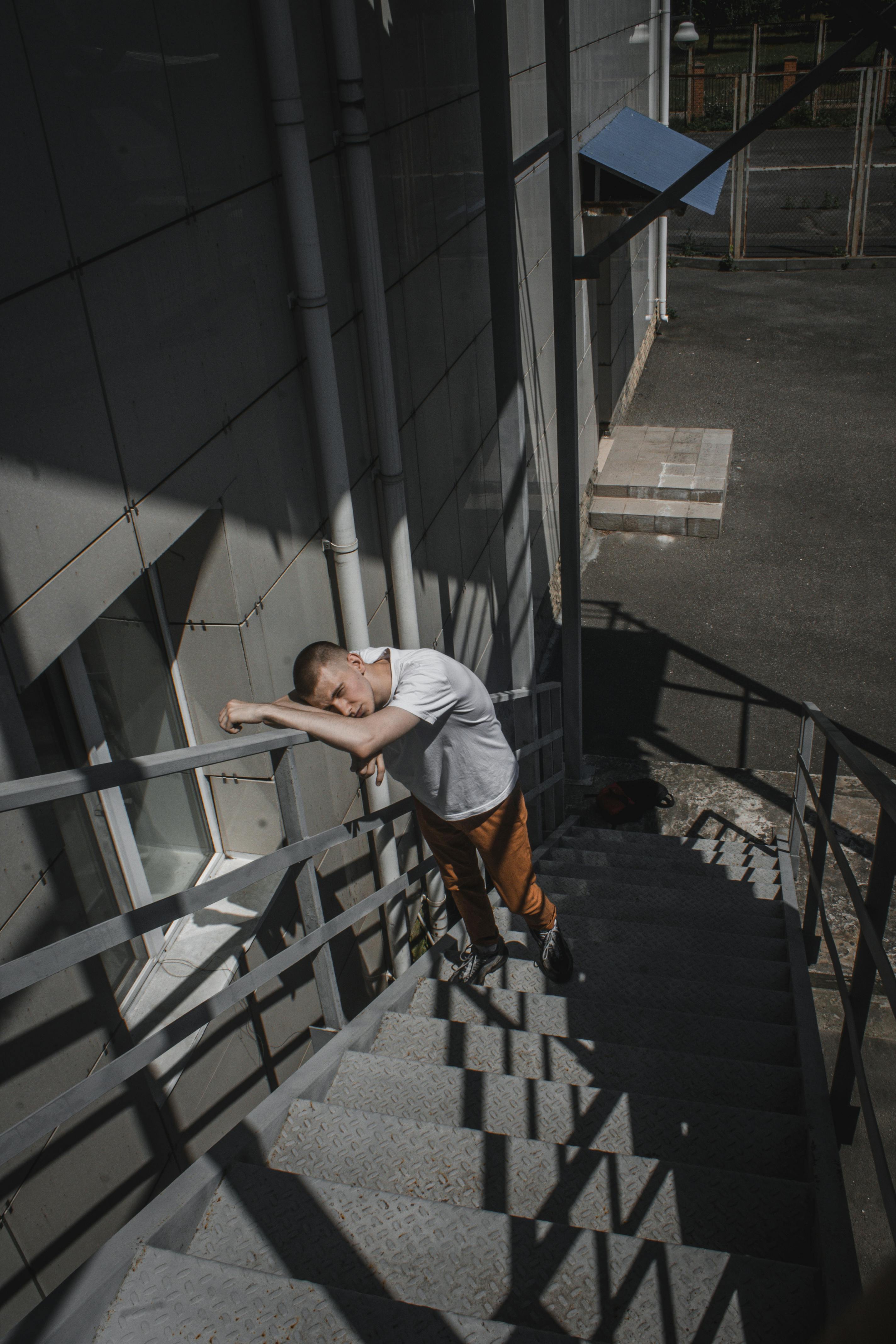 Young Guy Sitting on Stairs Posing · Free Stock Photo
