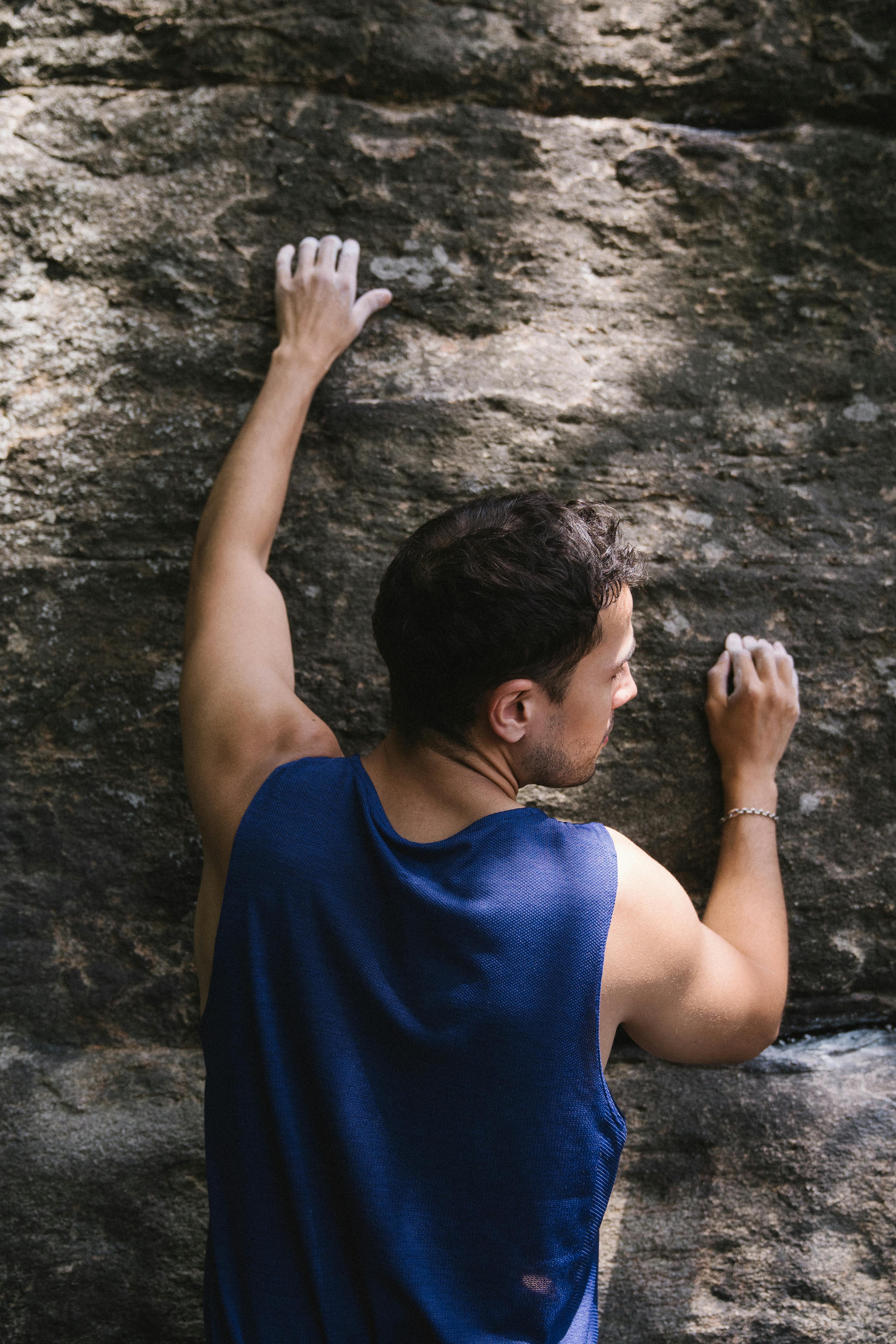 Back of a Man Climbing a Stone Wall · Free Stock Photo