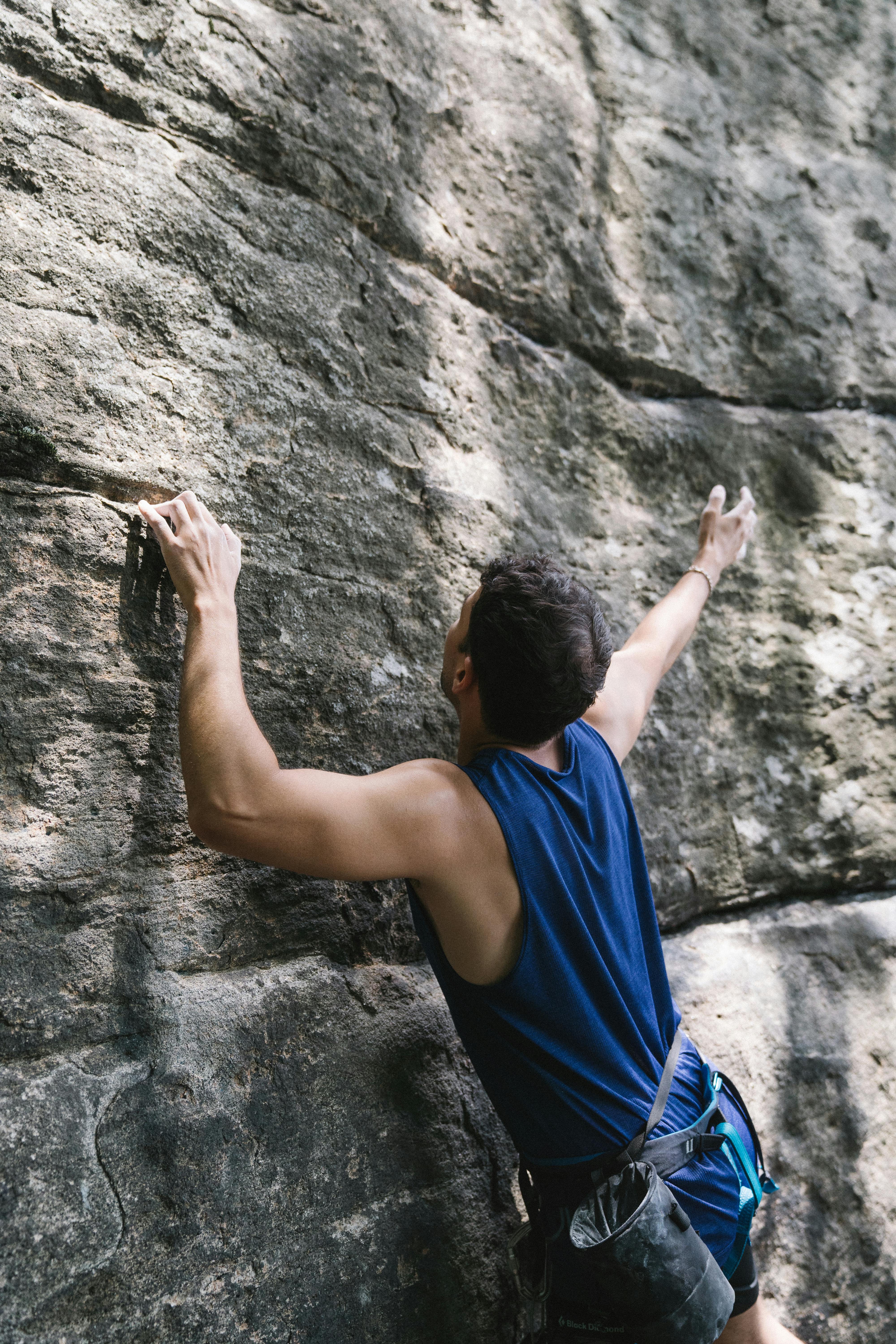 A Man in Blue Tank Top Climbing on the Wall · Free Stock Photo