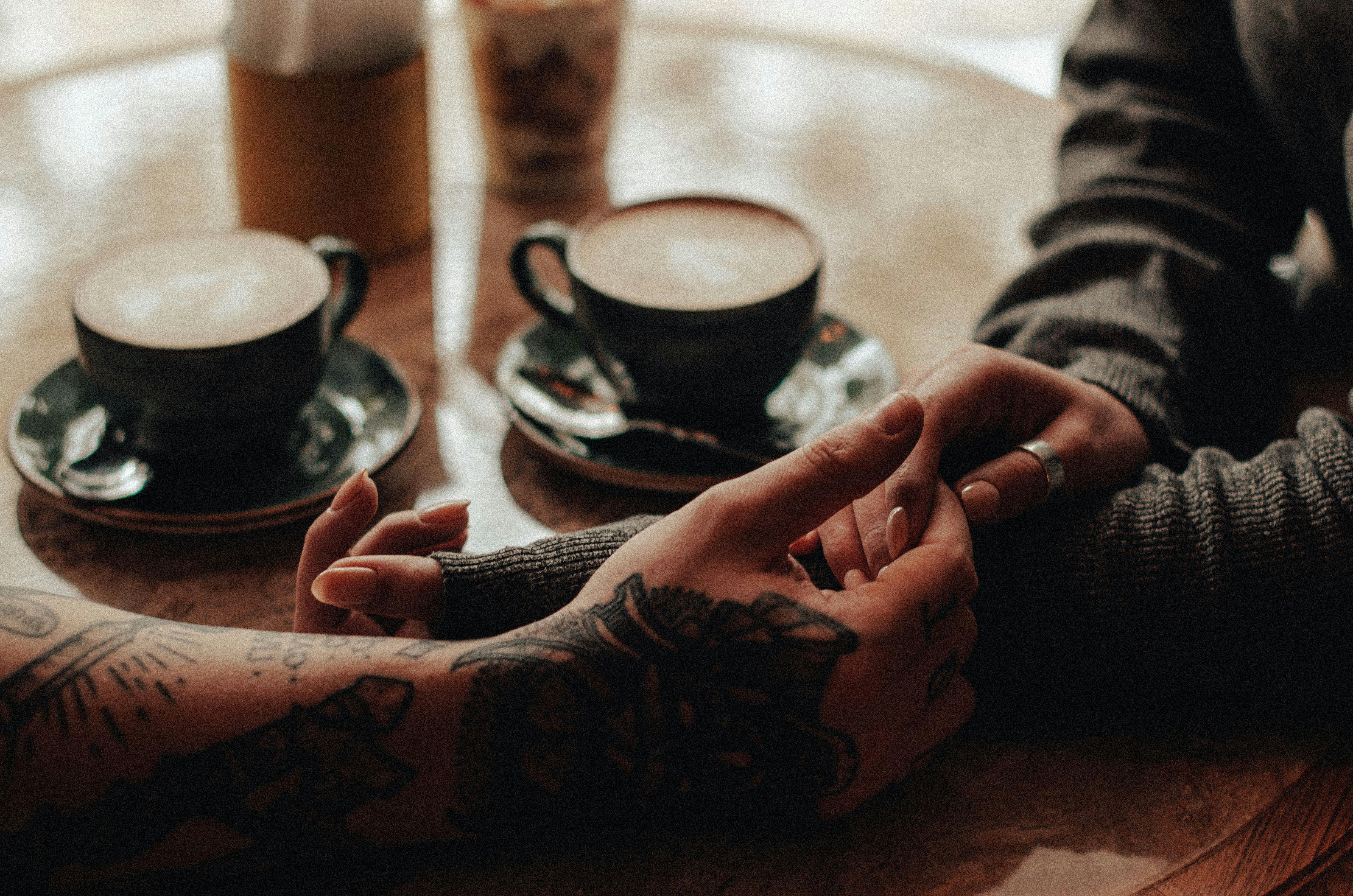 Man and Woman Holding Hands on a Table in a Cafe with Two Coffees in ...