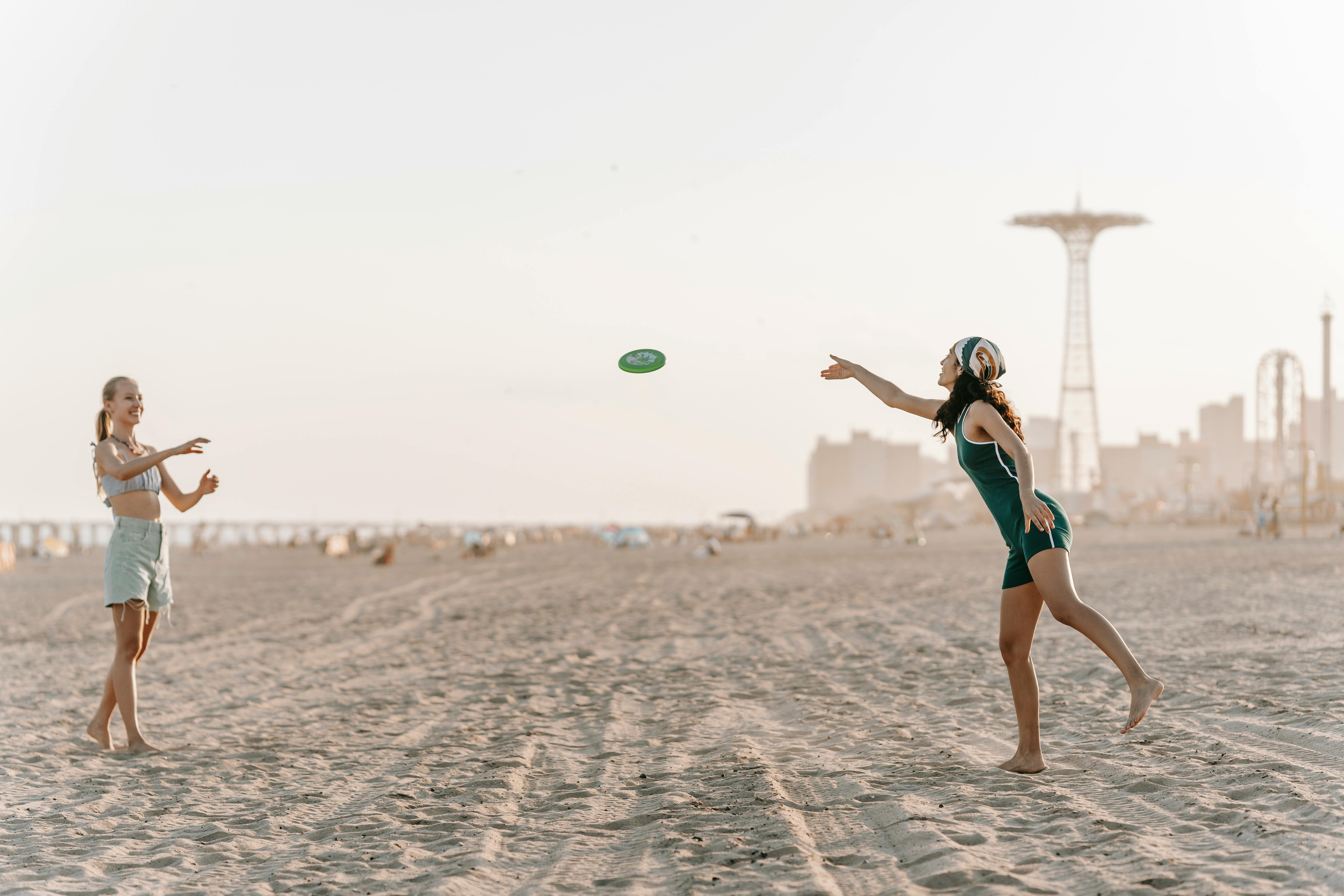 Two Women Playing Frisbee on the Beach · Free Stock Photo