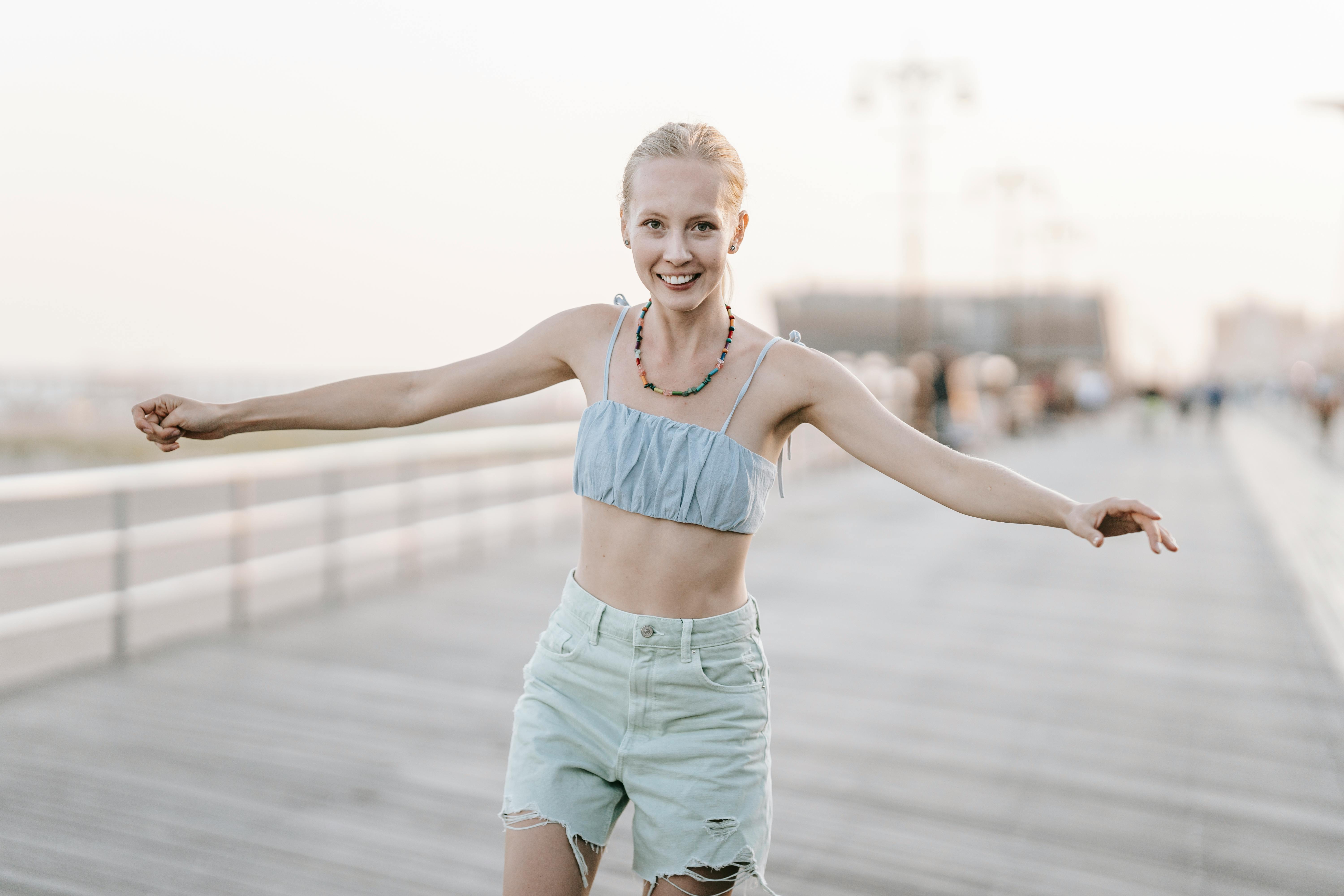 Smiling Girl with her Arms Raised · Free Stock Photo