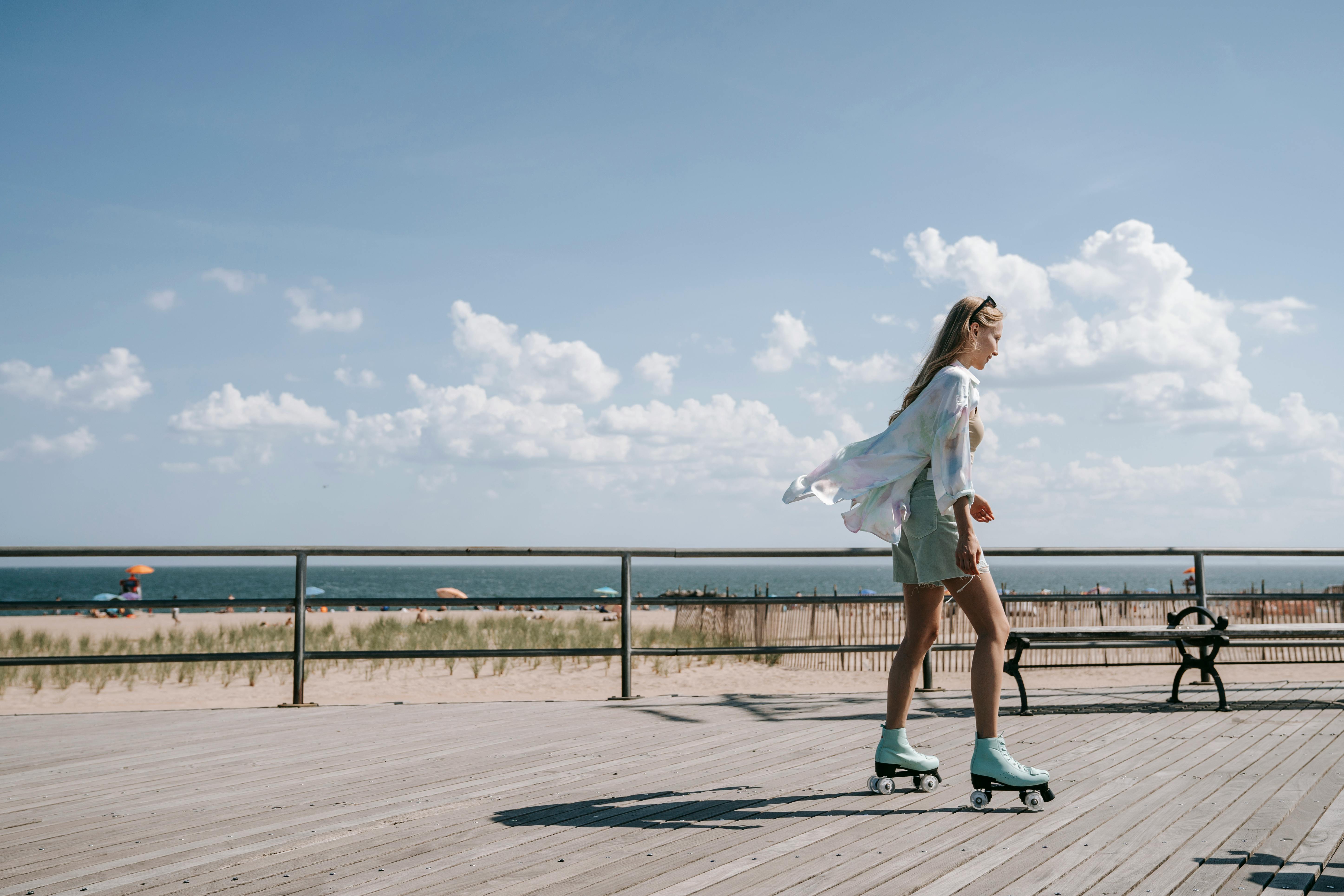 Woman Roller Skating on Pier by Sea Shore · Free Stock Photo