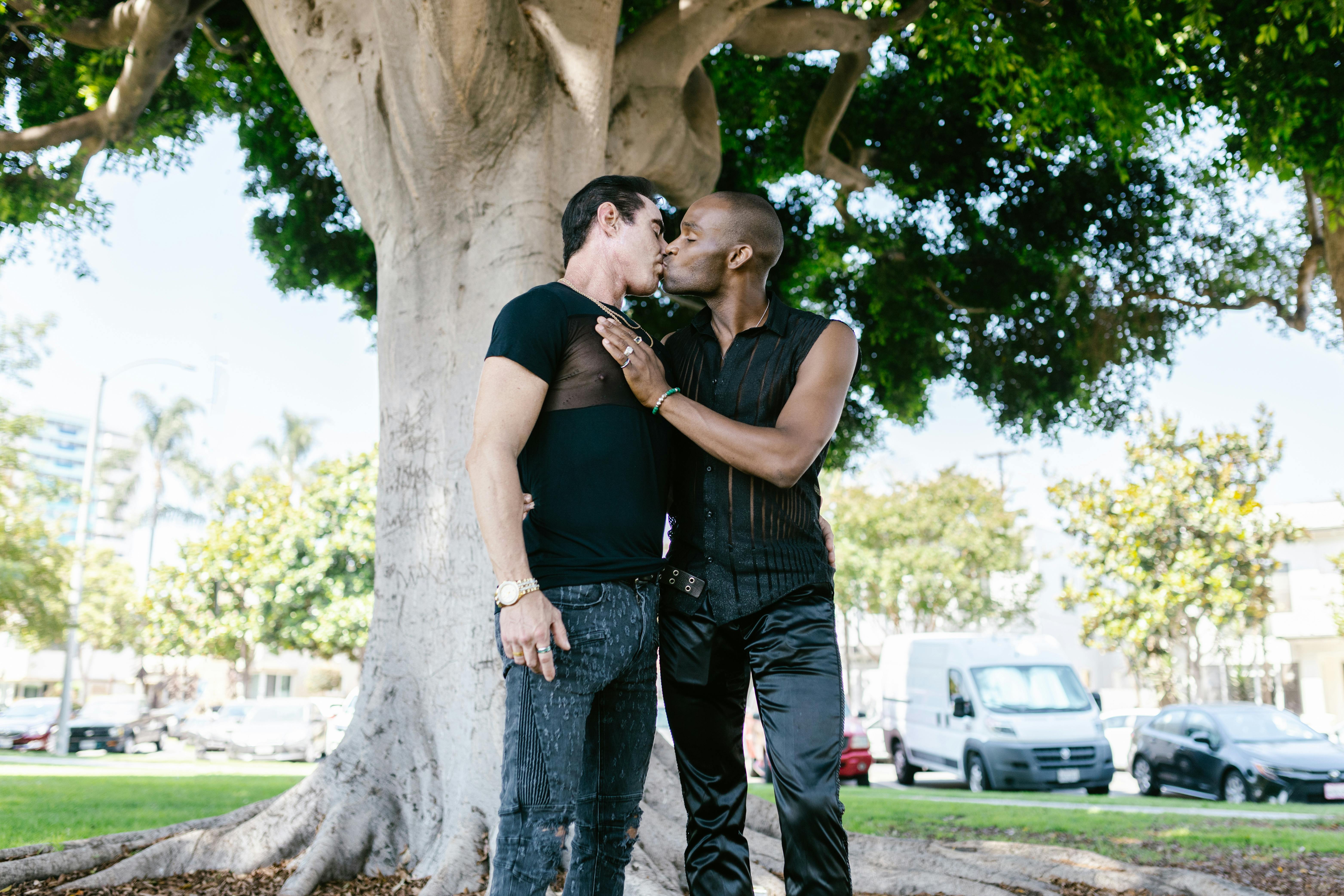 Photo of Men Kissing near a Tree · Free Stock Photo
