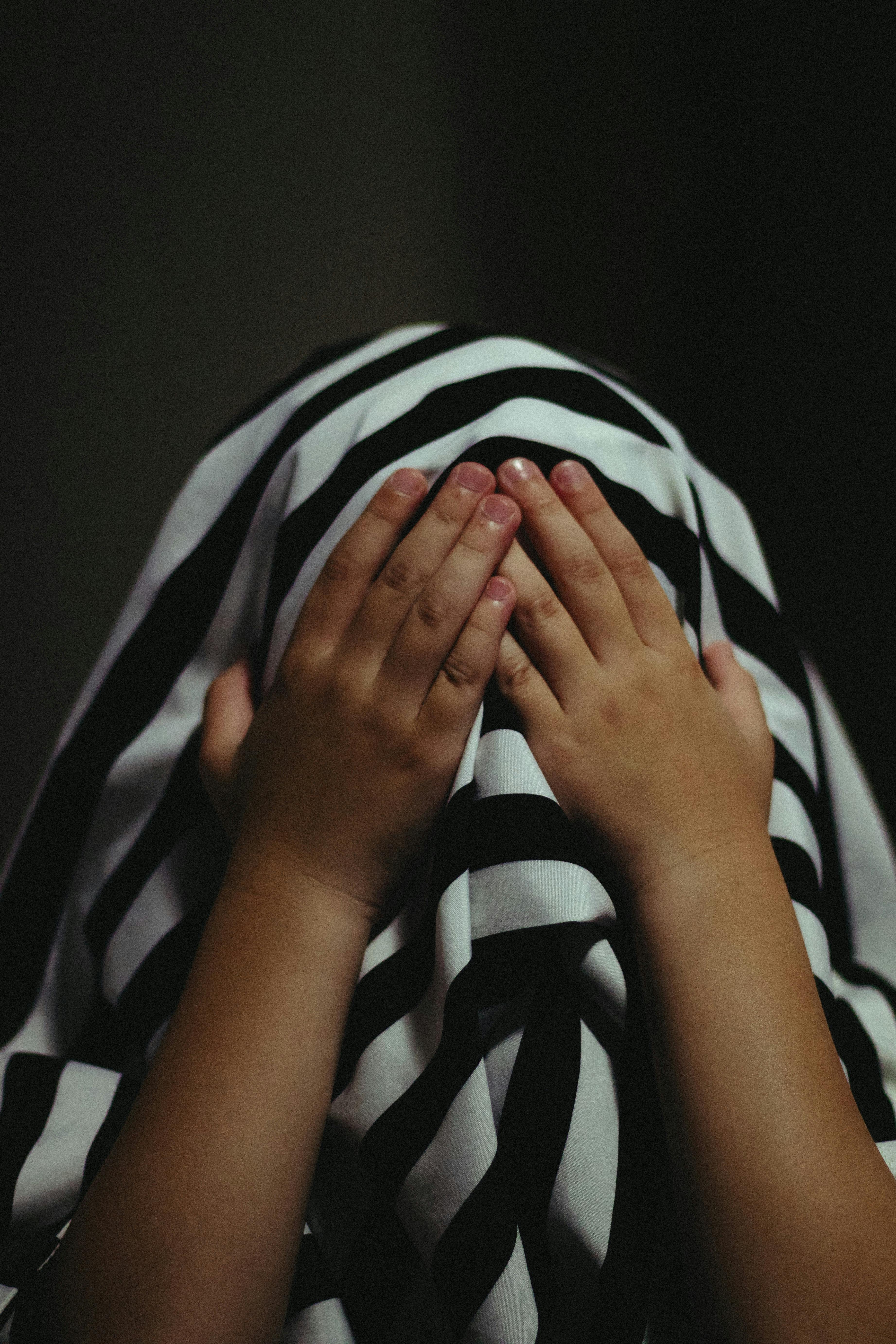 Anonymous black little kid hiding in wardrobe · Free Stock Photo