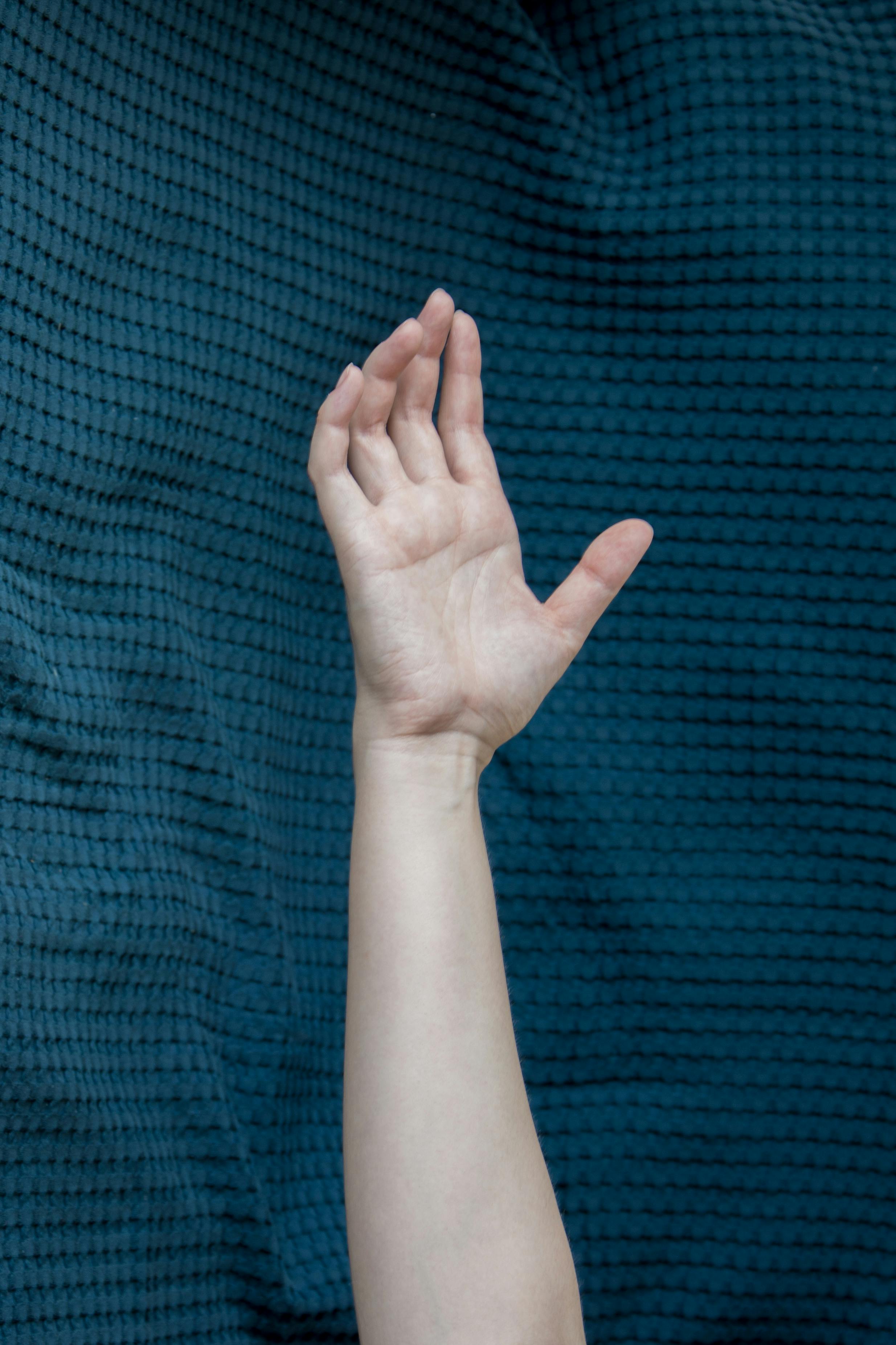 Pale Arm on the Background of a Navy Blue Fabric · Free Stock Photo