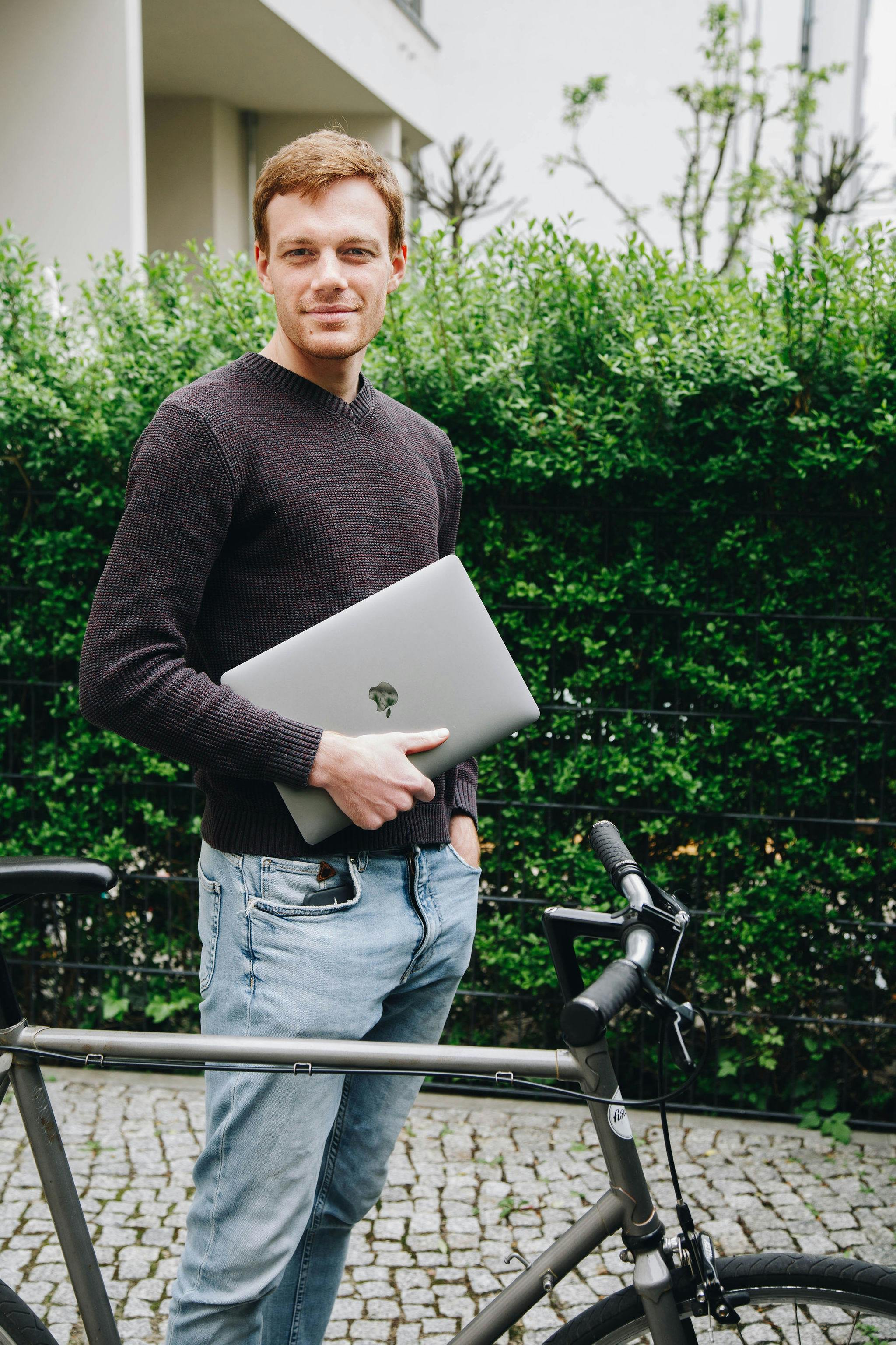 Man in Black Sweater Holding Macbook · Free Stock Photo