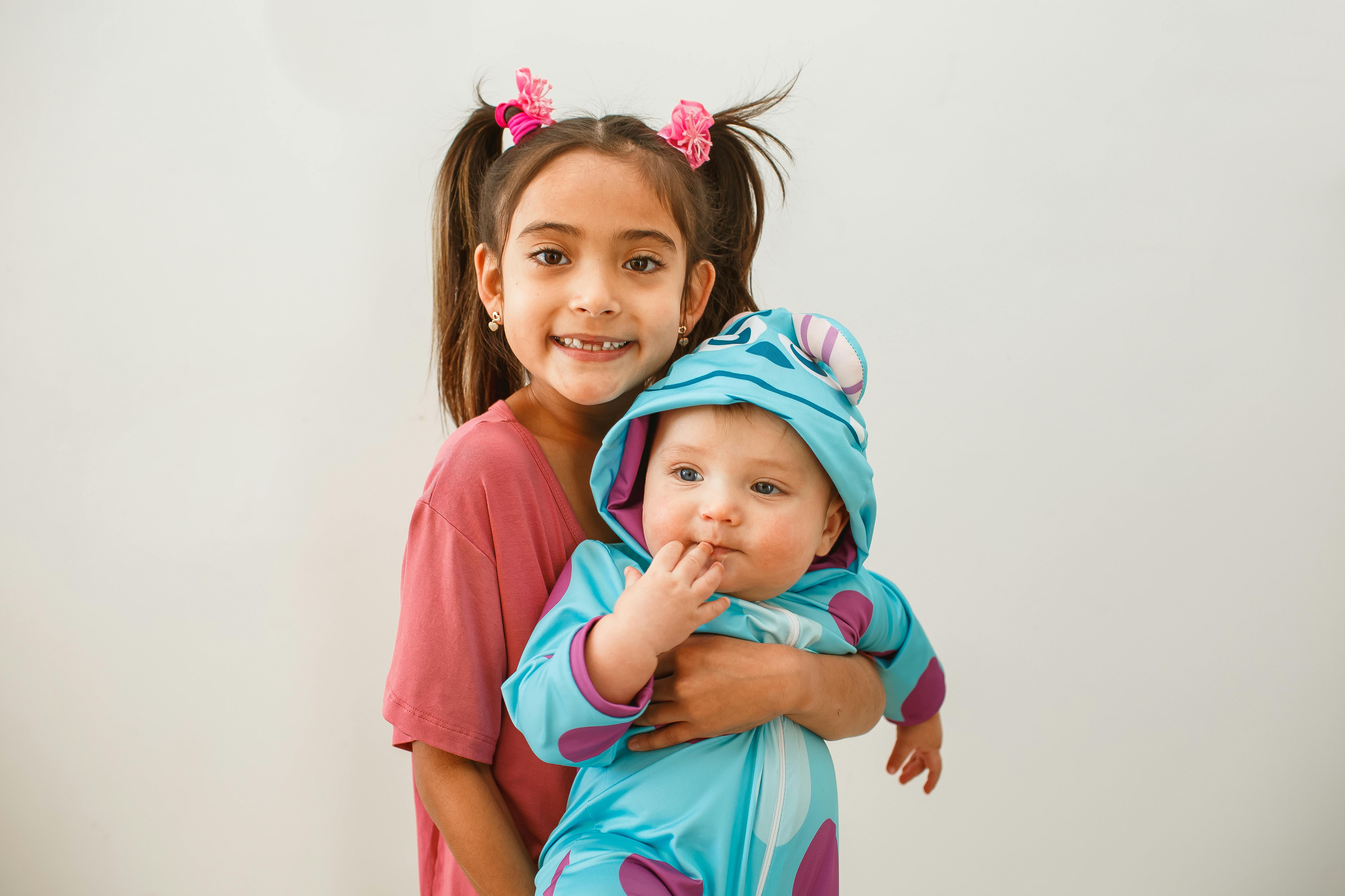 Girl Carrying a Baby · Free Stock Photo