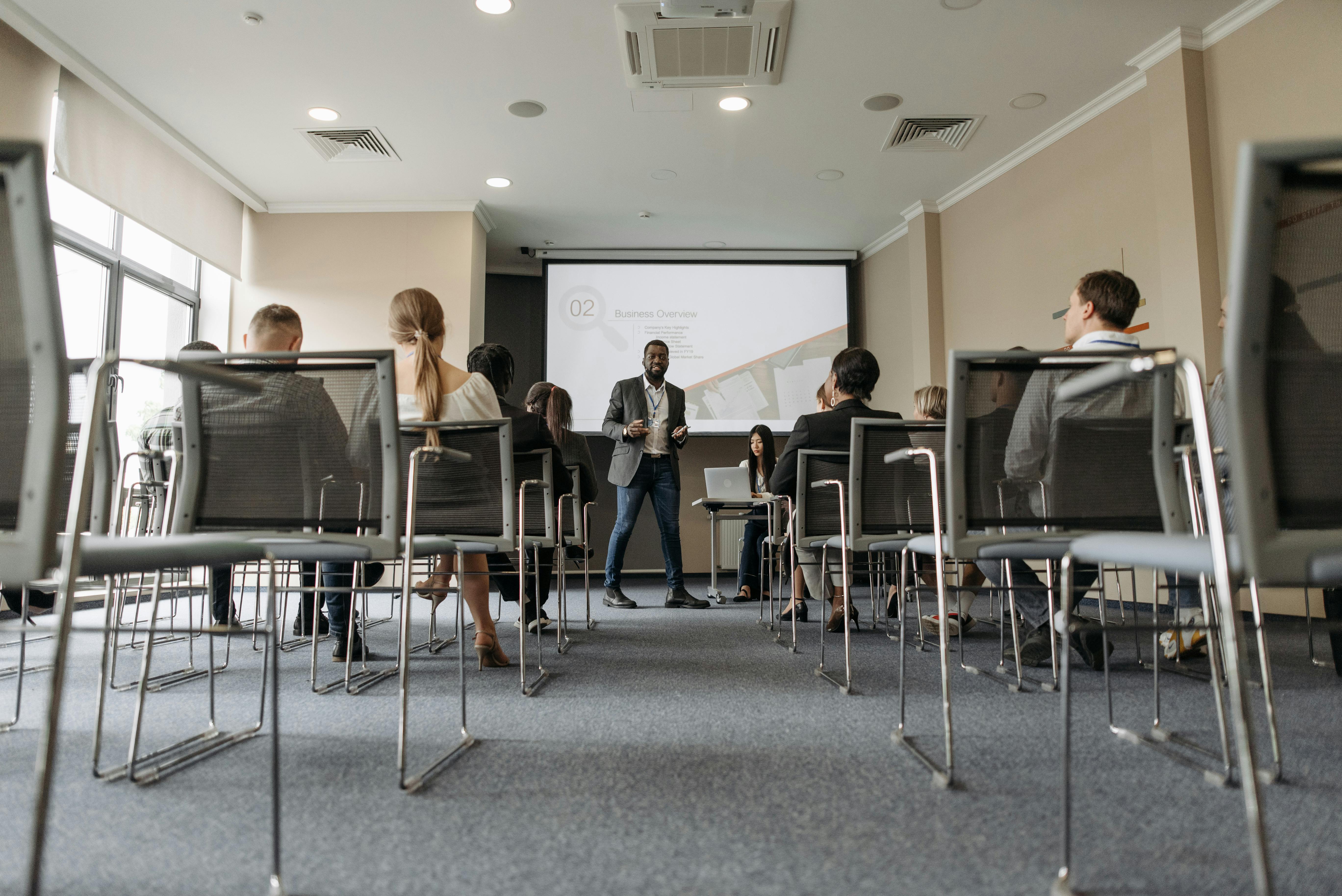 A Man Standing Near a Projector Screen · Free Stock Photo