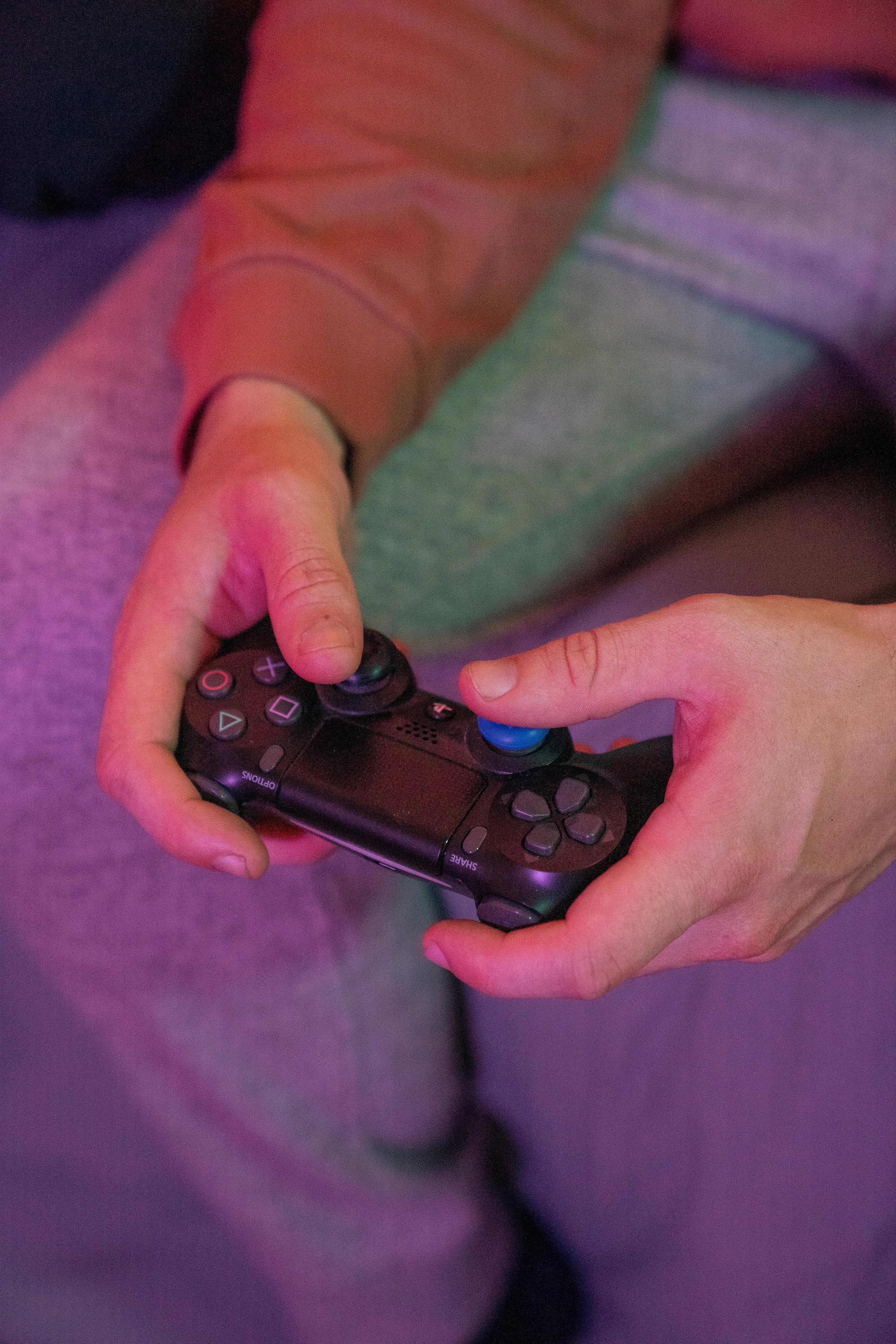 A Chained Hand Holding Game Controller · Free Stock Photo