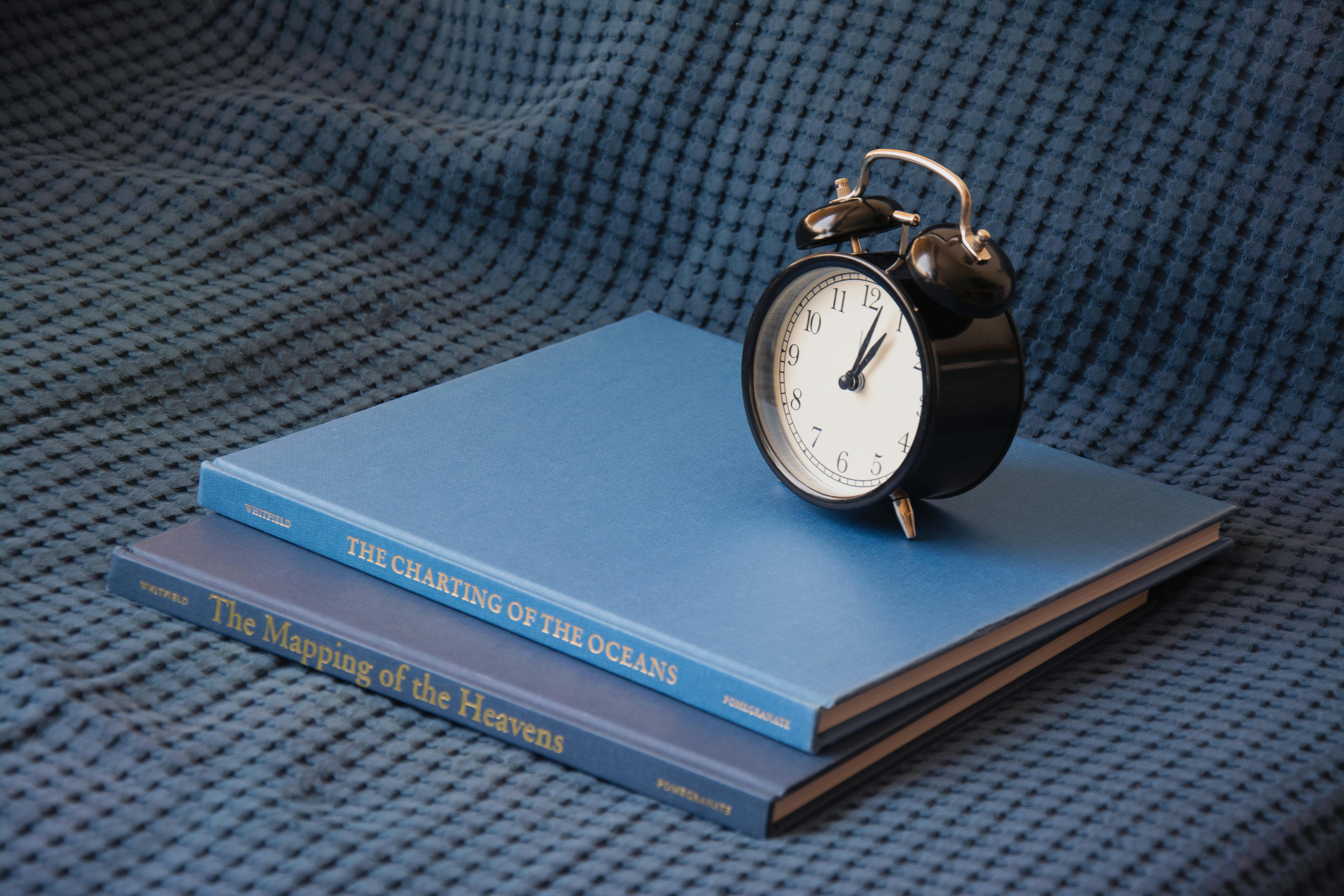 Black Alarm Clock on Top of the Books · Free Stock Photo