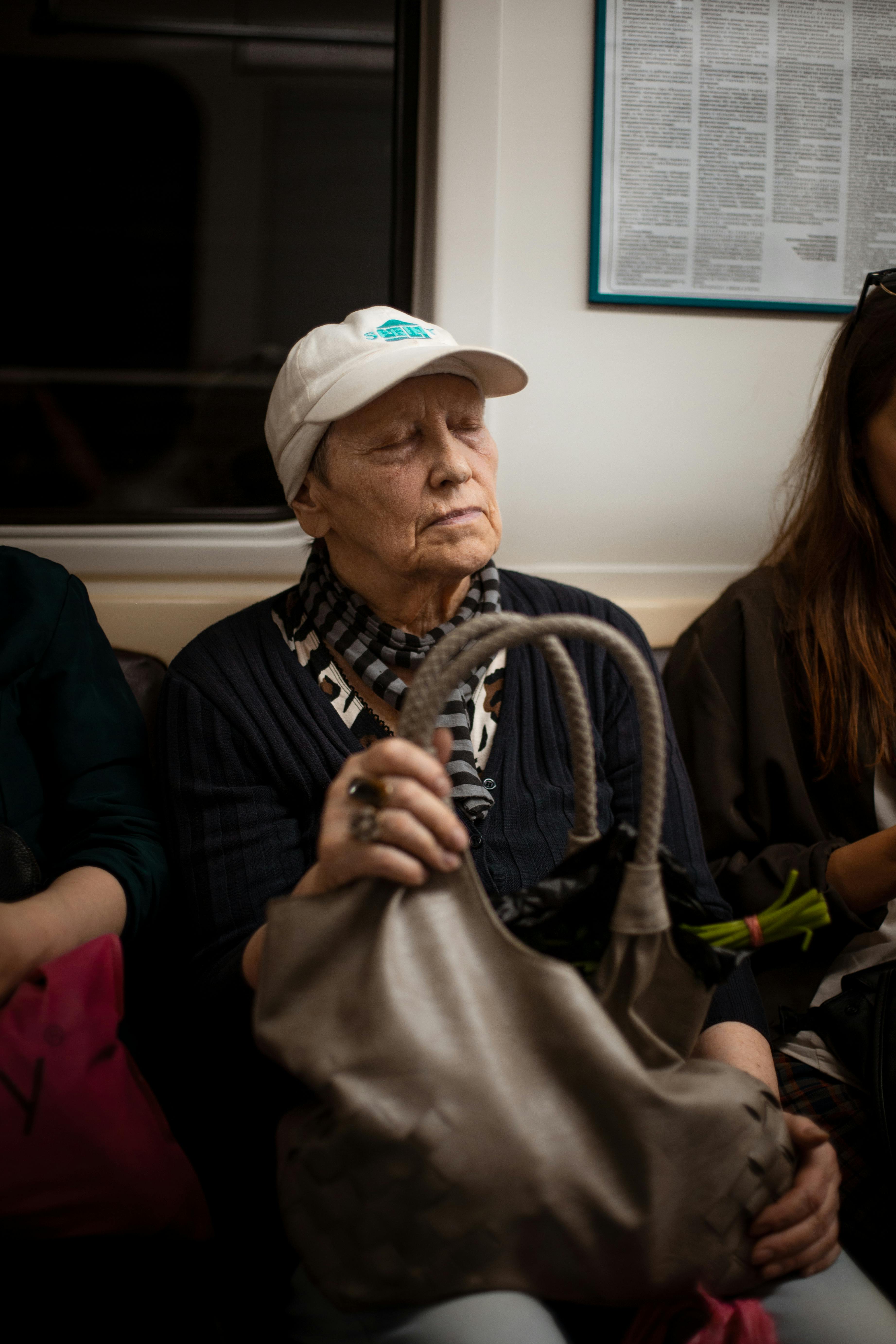 Elderly Woman Sitting on Train Seat · Free Stock Photo