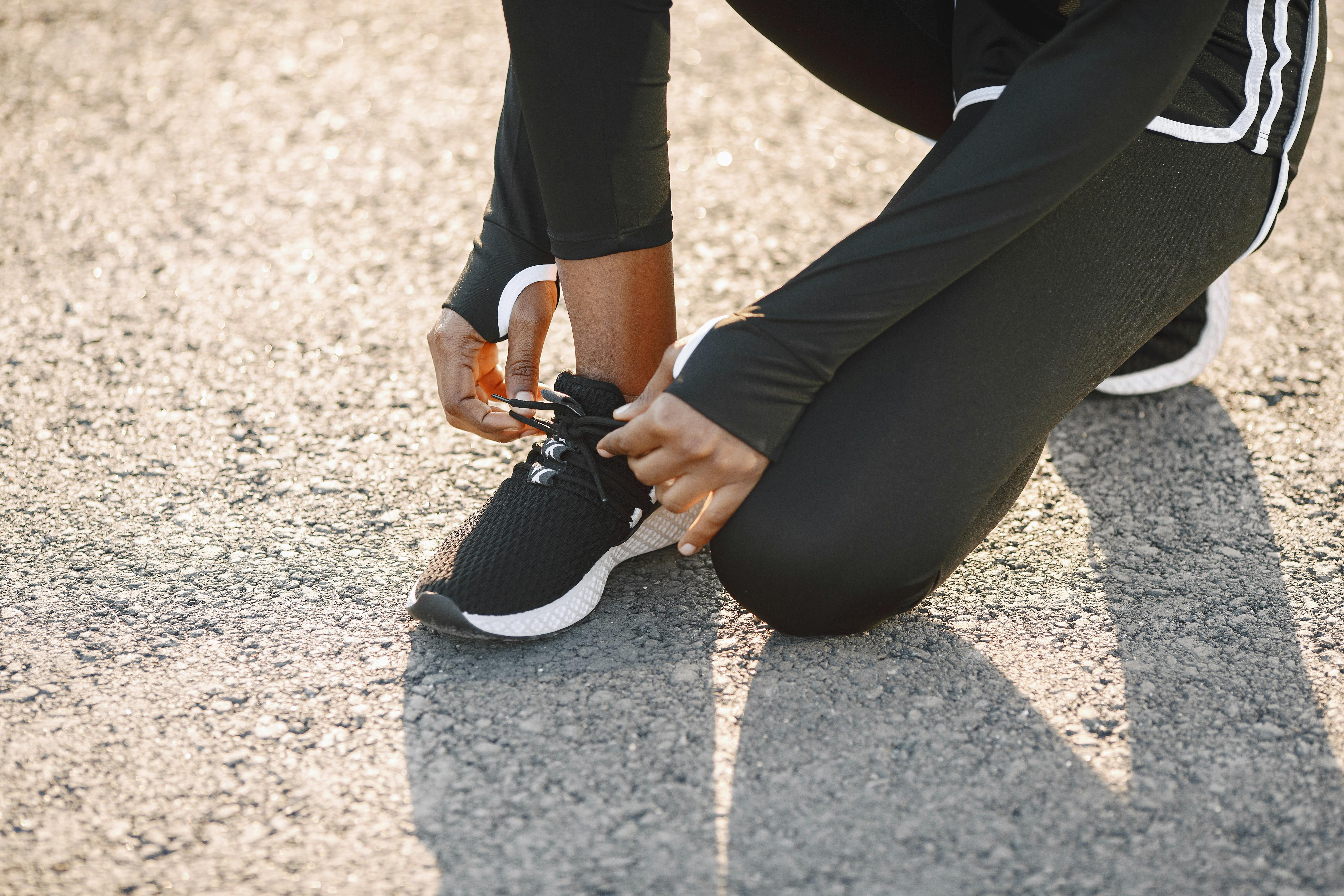 Close-Up Shot of a Person Tying Shoes · Free Stock Photo