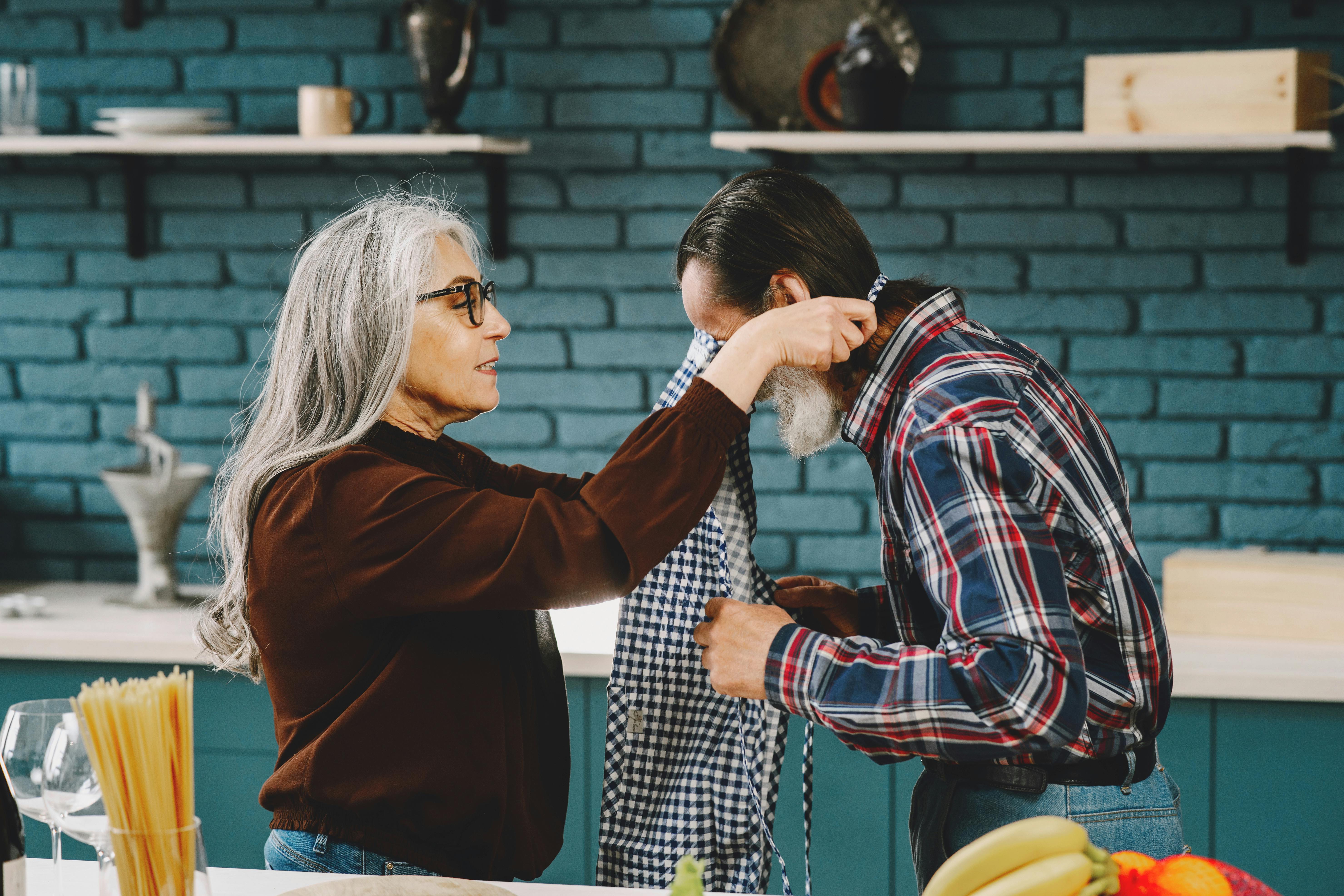 Elderly Woman helping her Husband with his Apron · Free Stock Photo