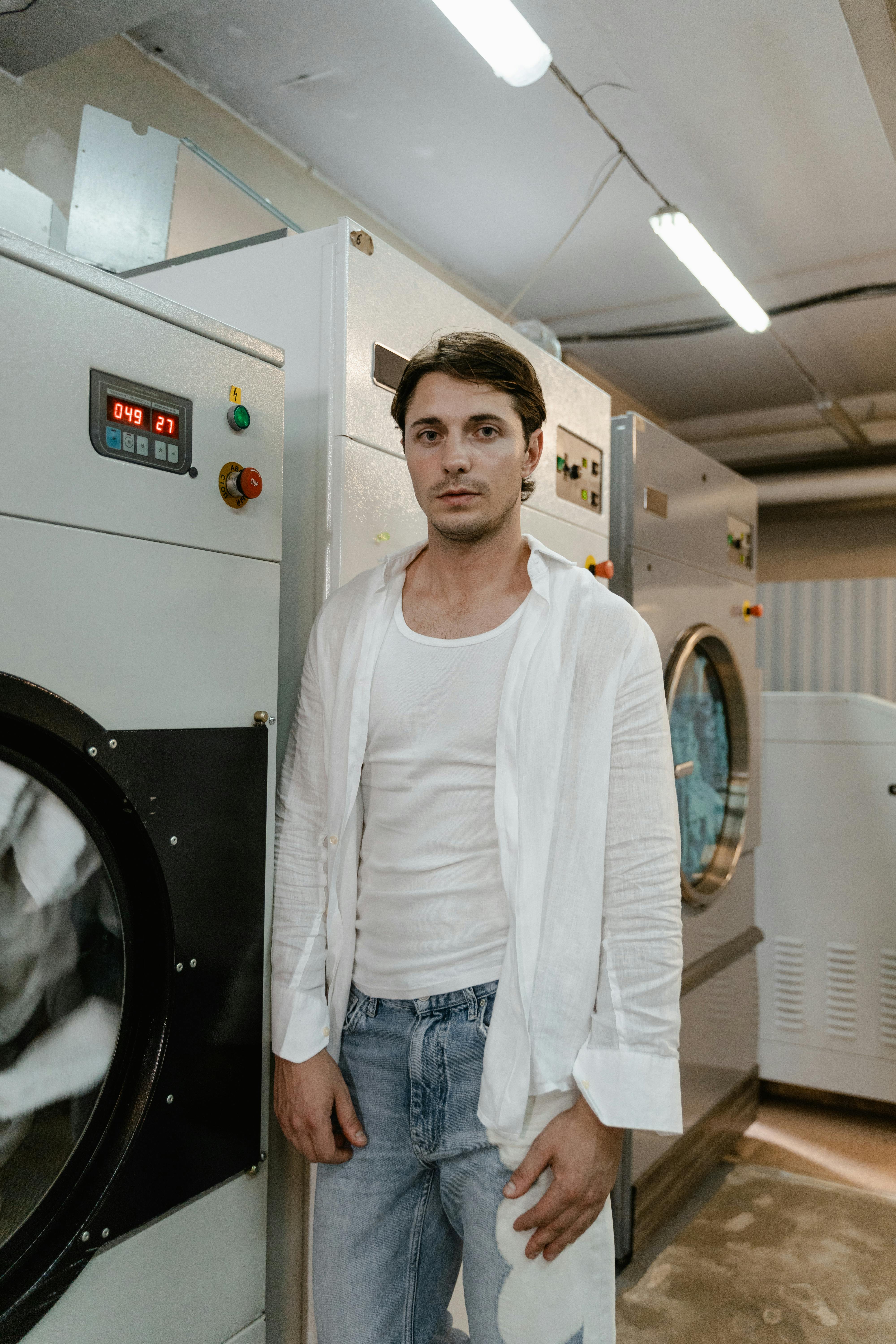 A Man Standing Beside Washing Machines · Free Stock Photo