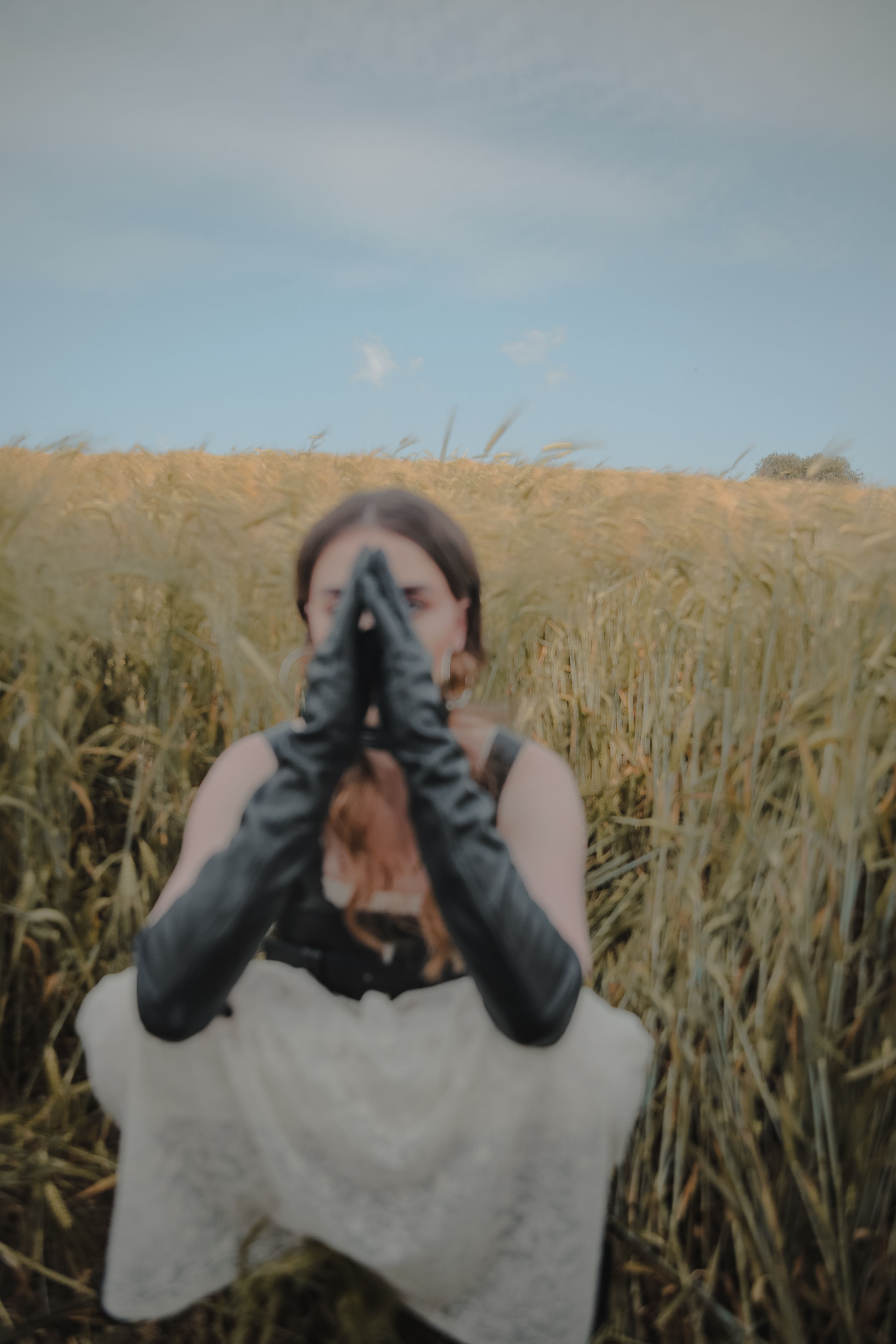 Woman Crouching in a Field Covering her Face · Free Stock Photo