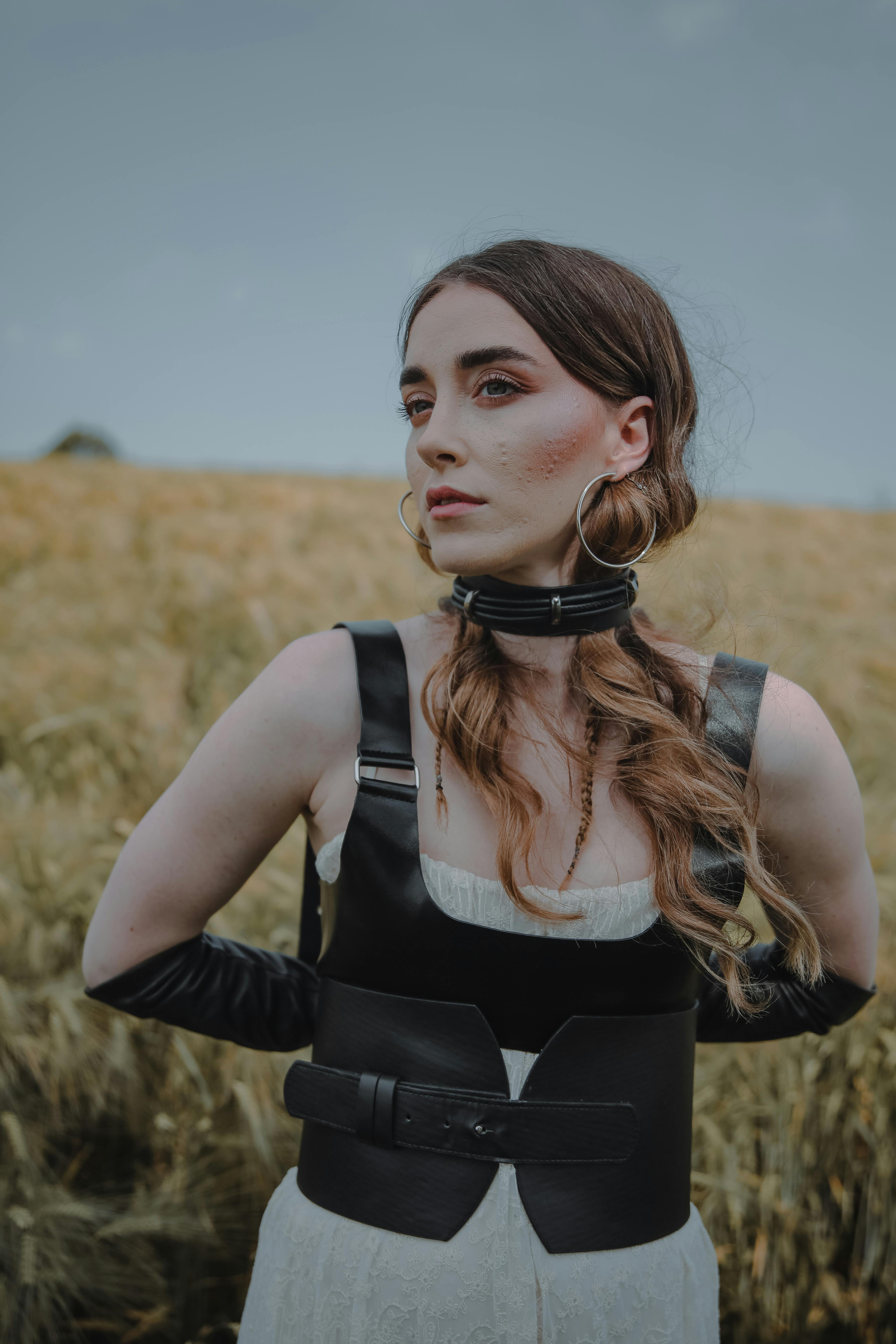 Long Haired Woman in a Field Wearing Harness and Collar · Free Stock Photo