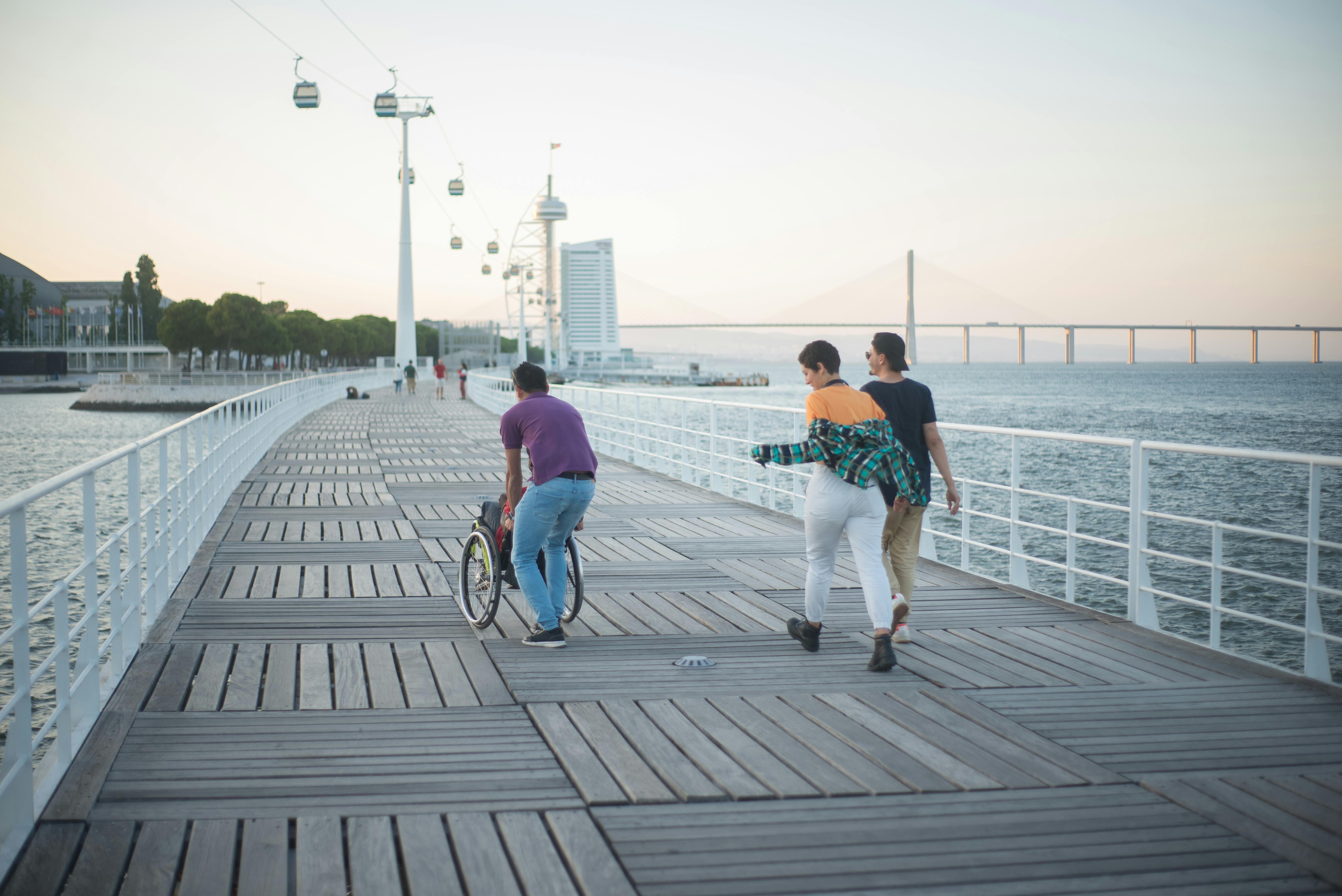 People Walking on the Bridge Near the Sea · Free Stock Photo