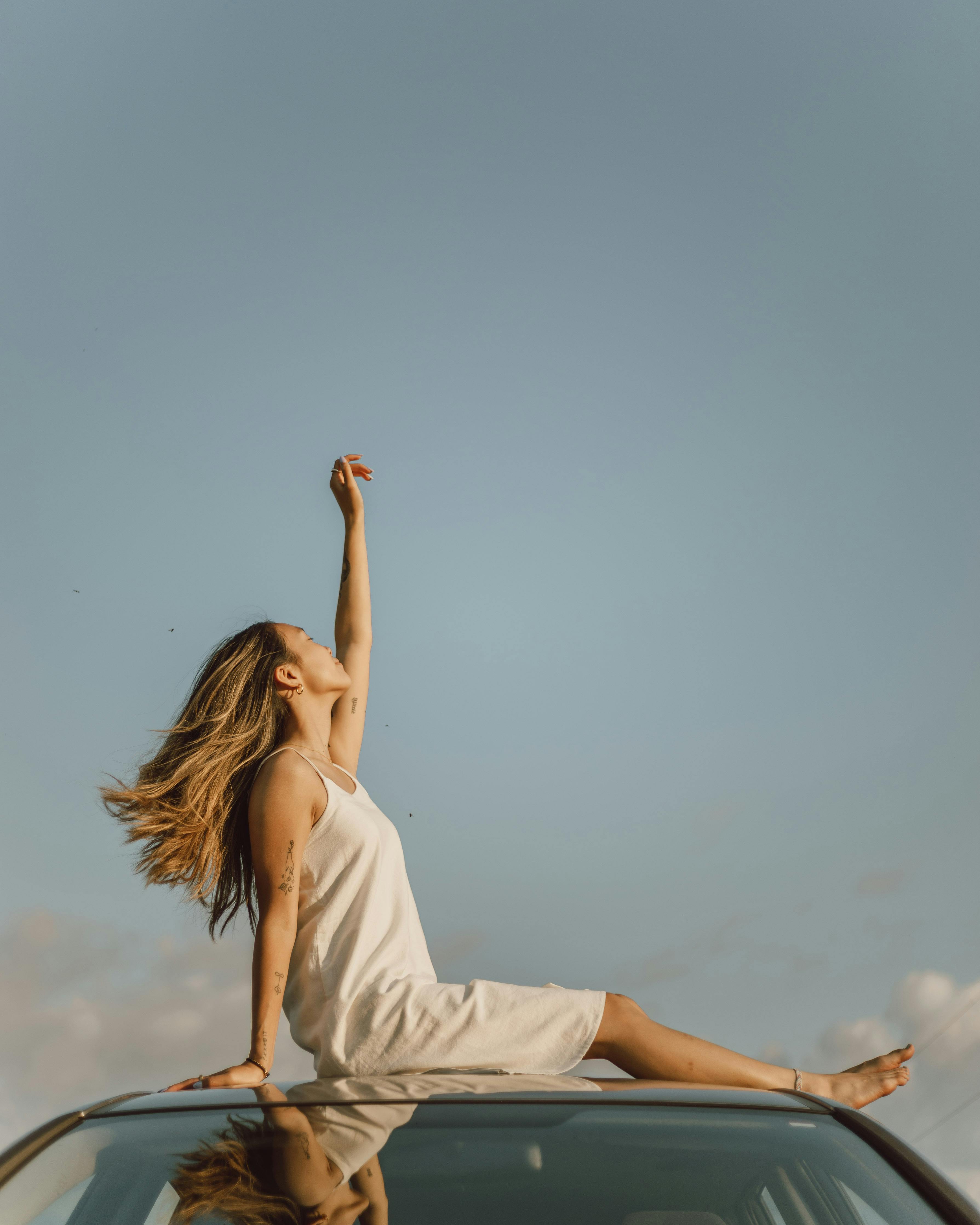 Back View of a Woman Raising Her Hands · Free Stock Photo