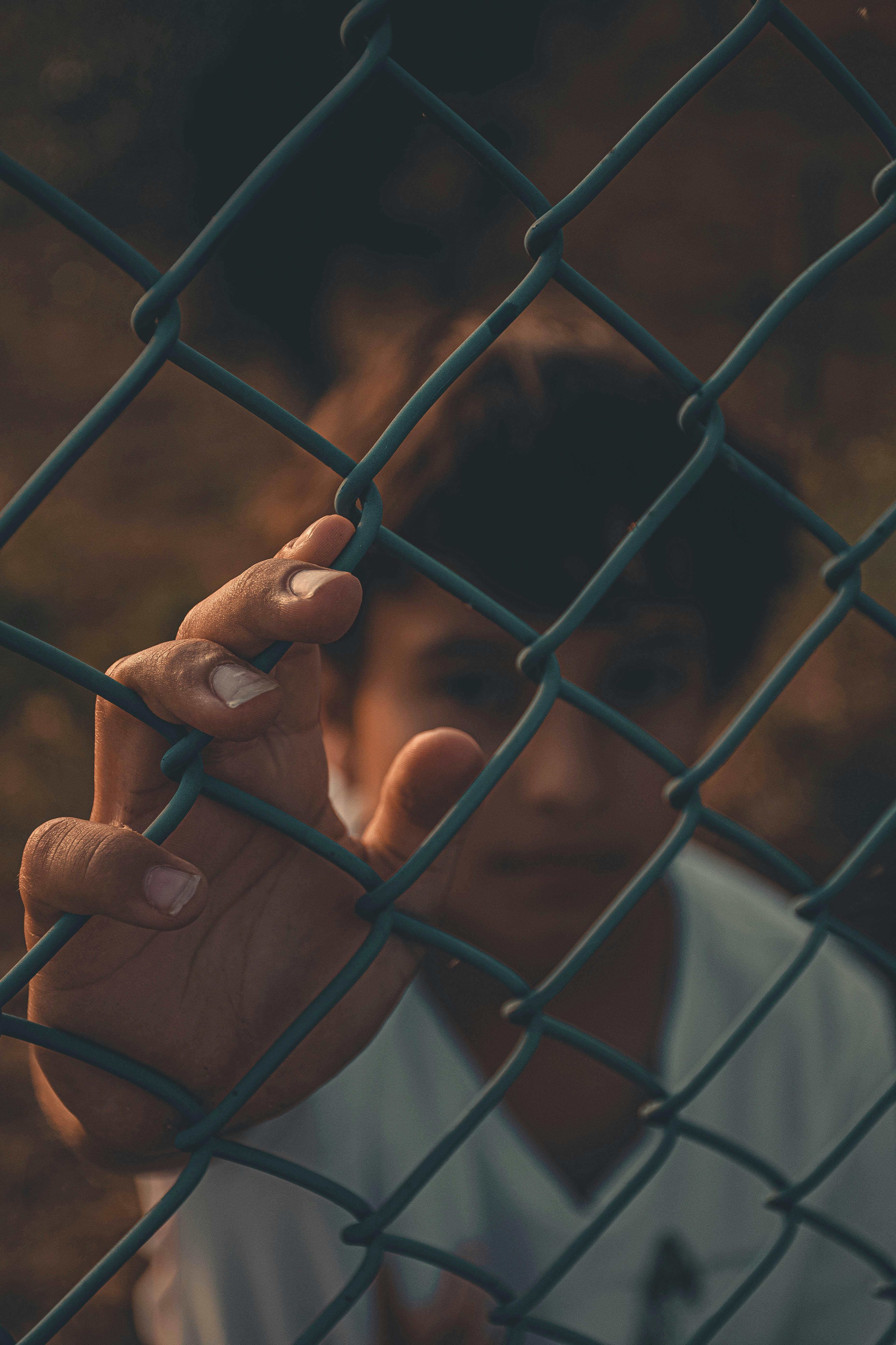 Woman Holding on Chain Link Fence · Free Stock Photo