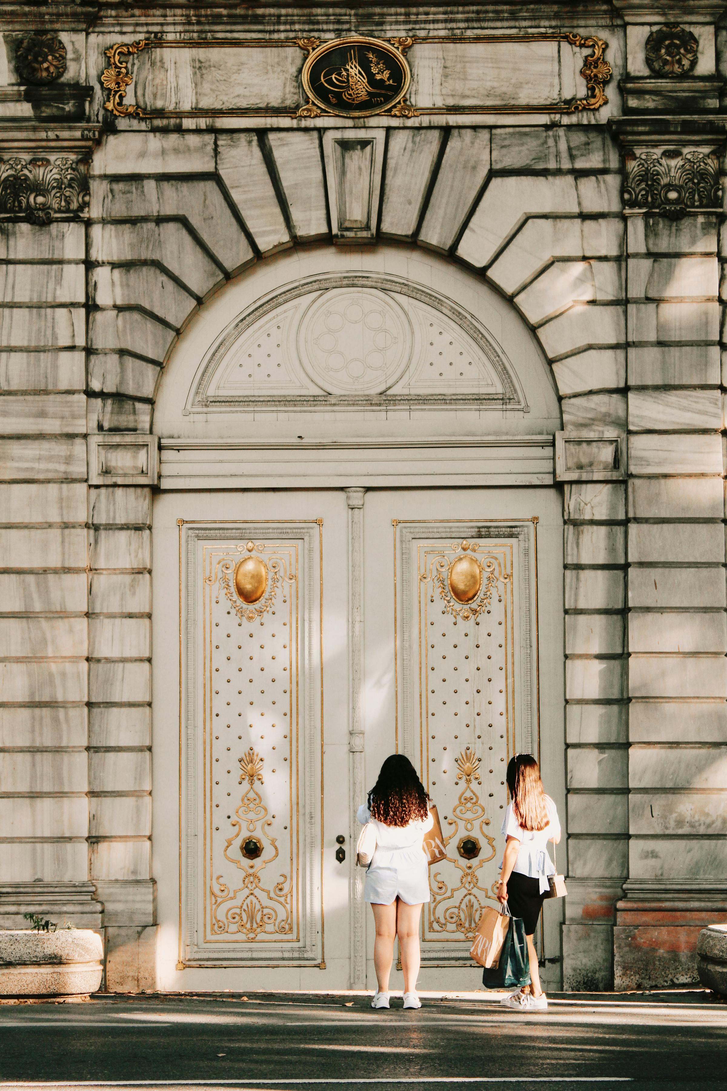 A Back View of Women Standing in Front of the Door · Free Stock Photo