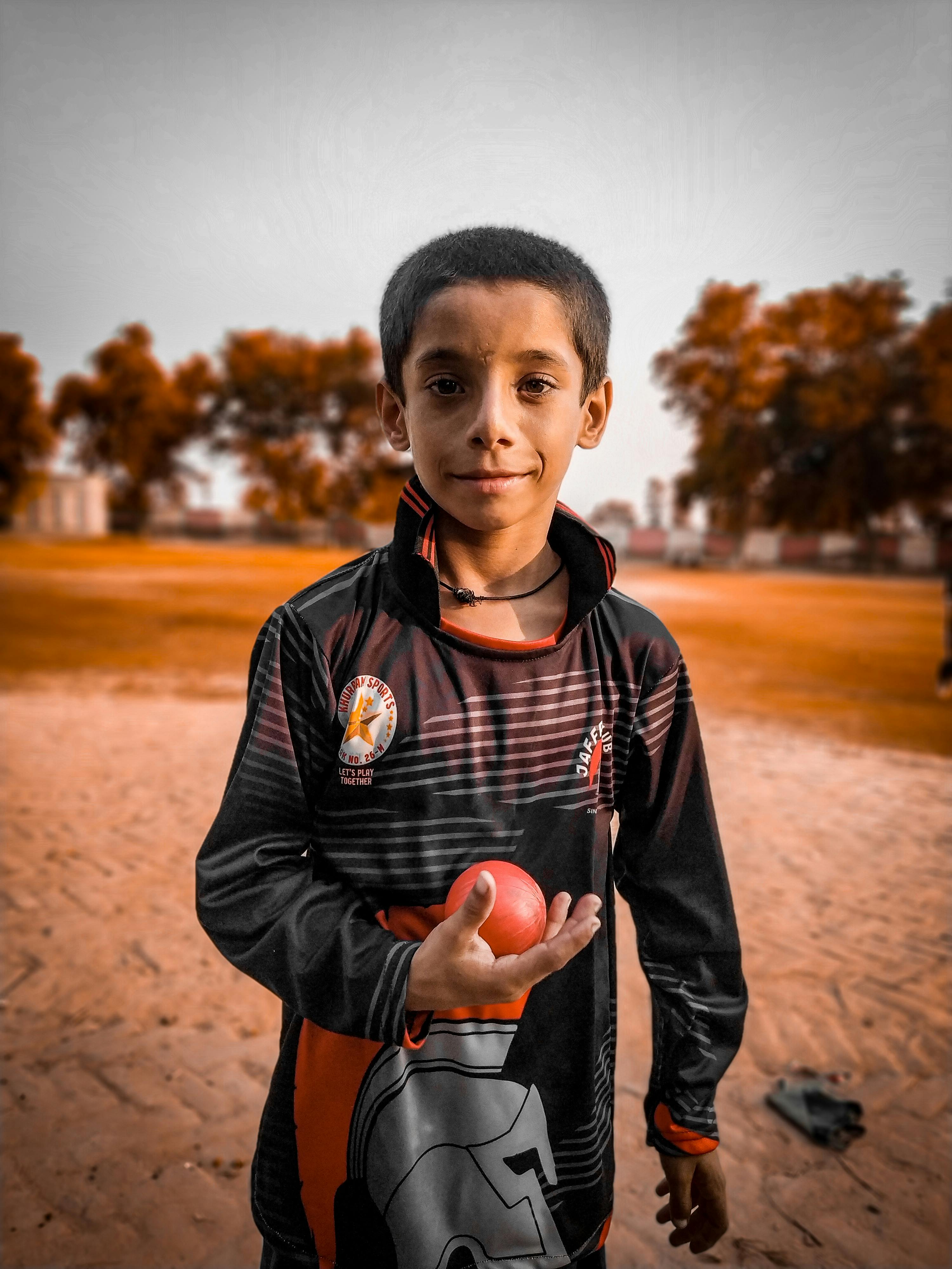 A Portrait of a Boy Holding a Ball · Free Stock Photo