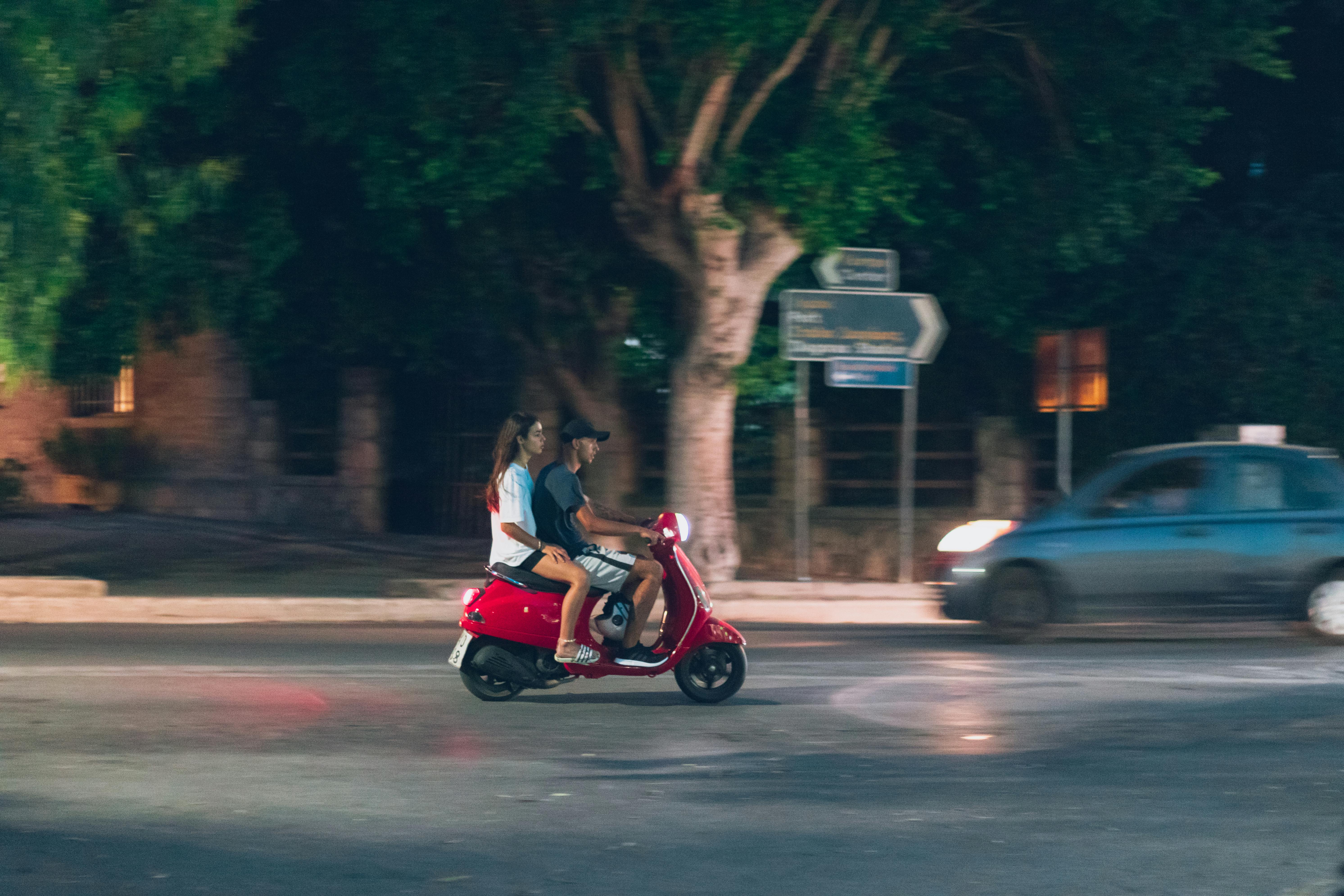 Couple Riding a Red Scooter During Nighttime · Free Stock Photo