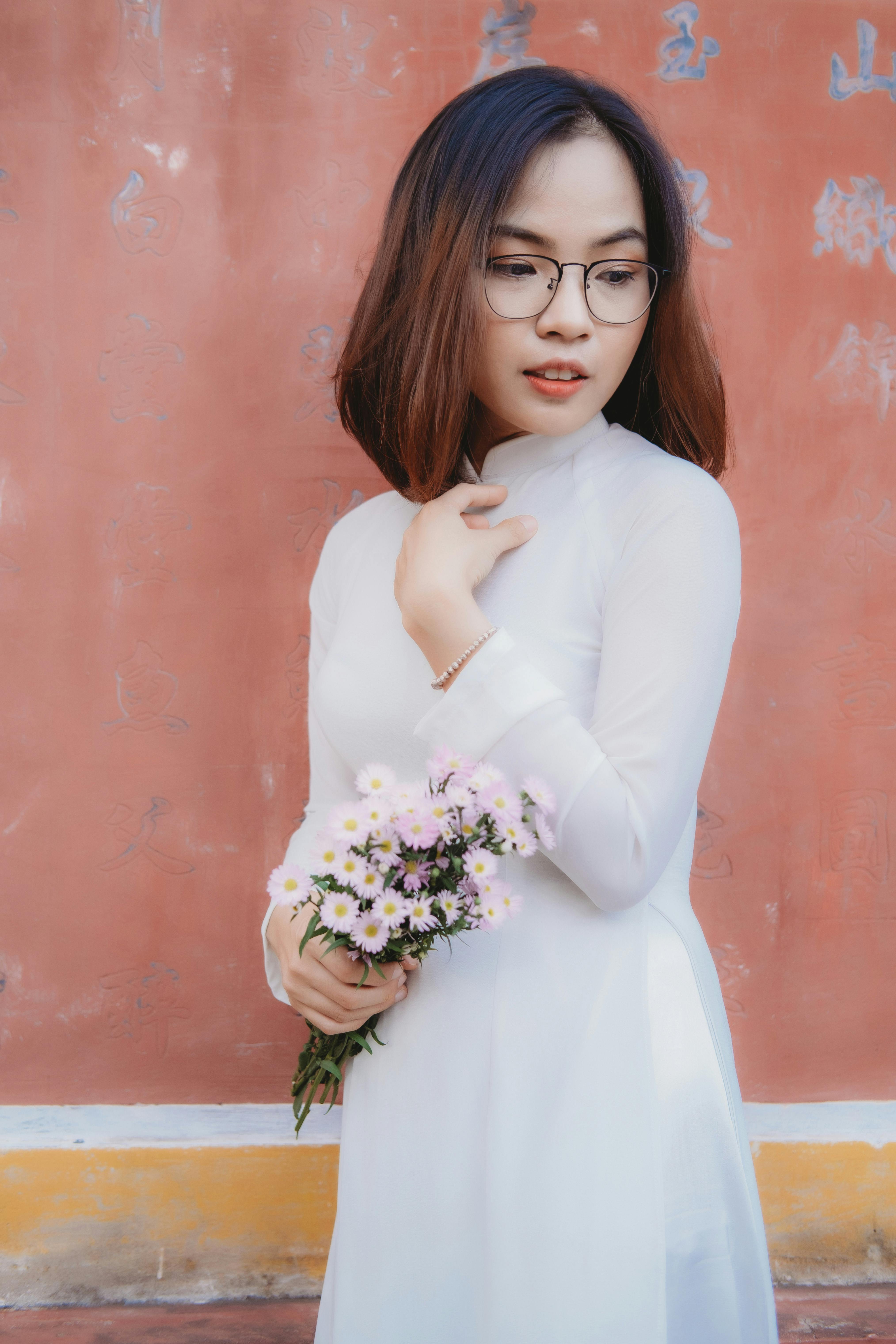 Woman Wearing Long Sleeves Dress Covering Face With Bouquet of Flowers ...