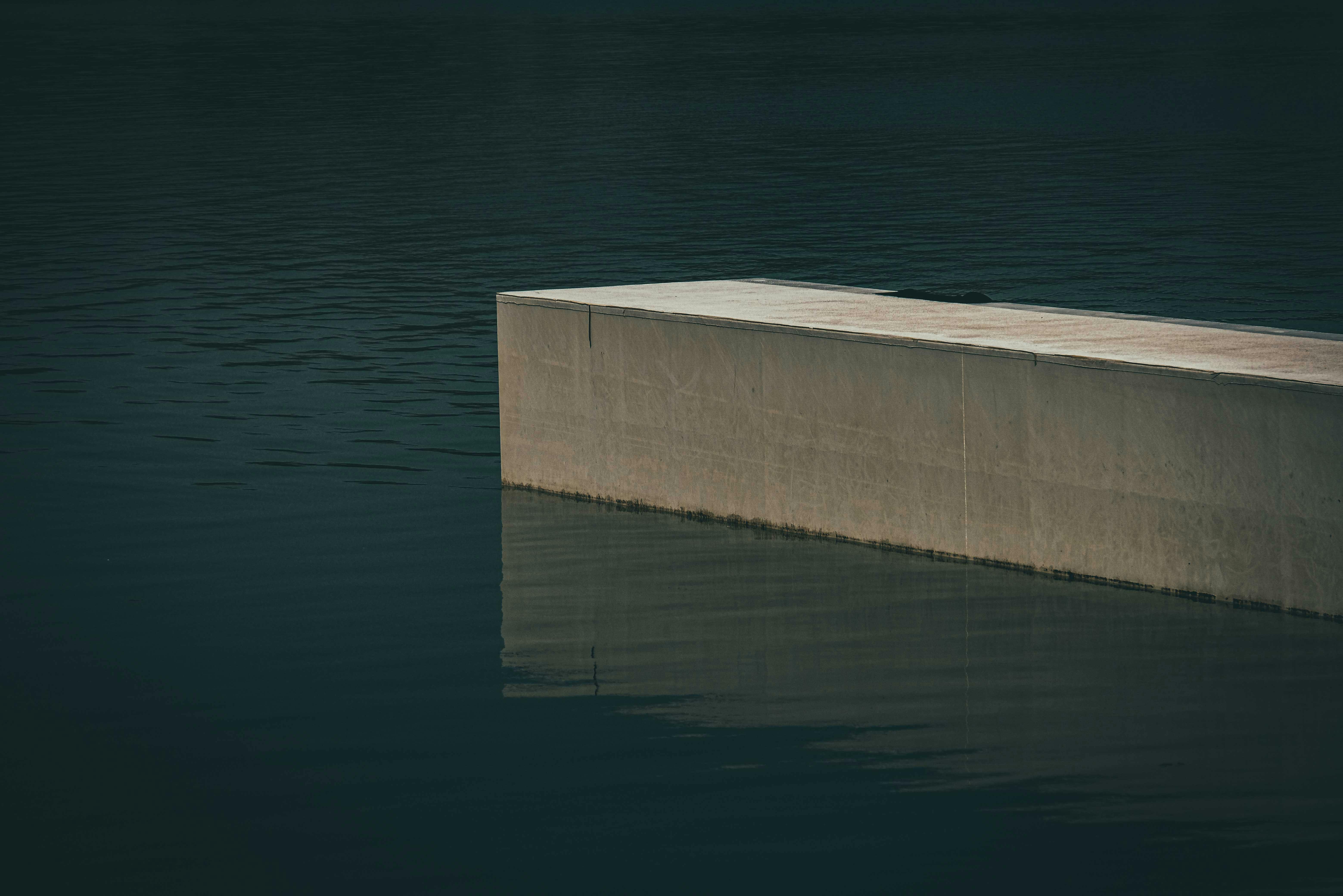 Concrete Wave Breaker Reflecting in Water · Free Stock Photo