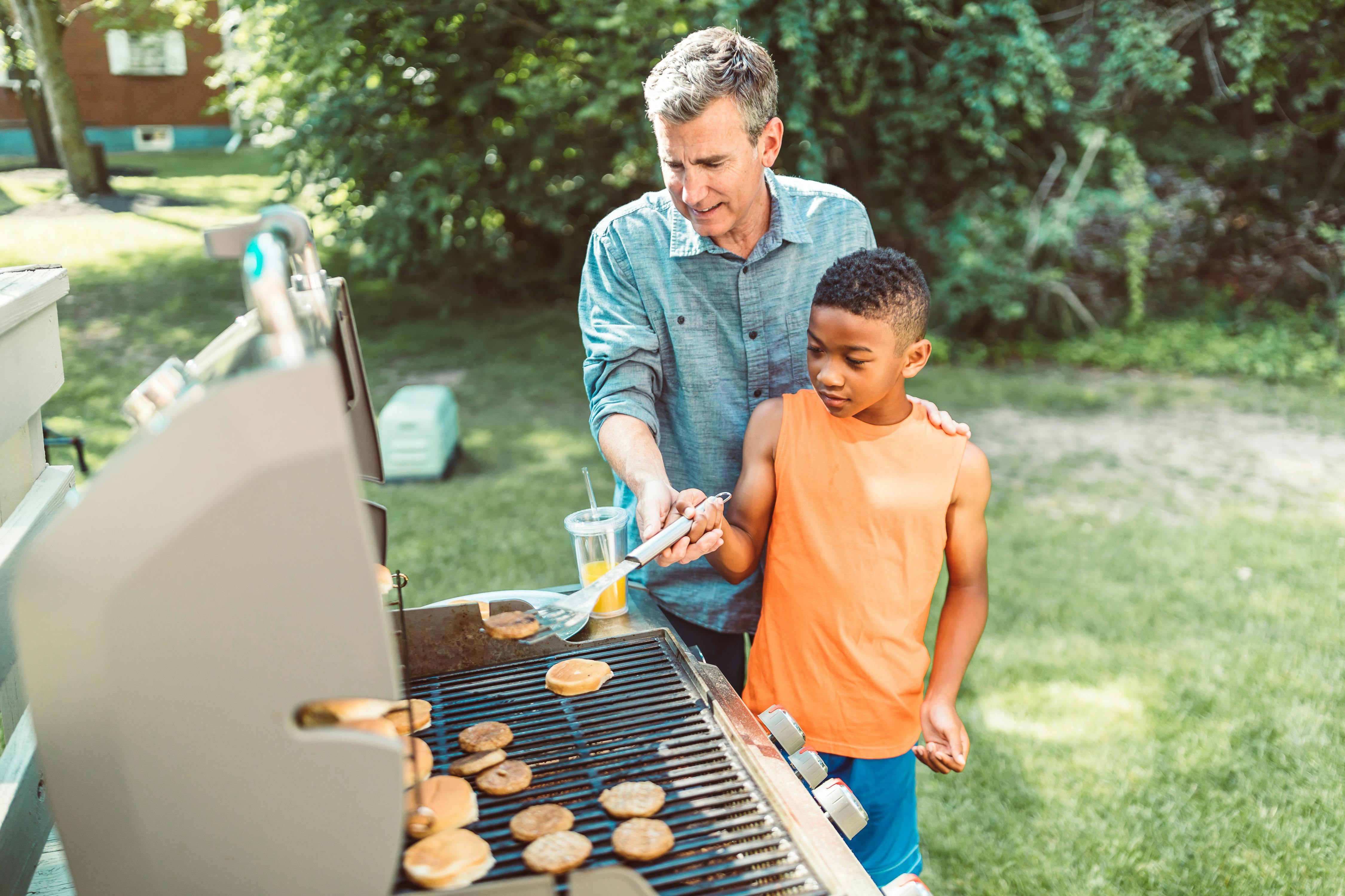 Father grilling Patties together with his Son · Free Stock Photo
